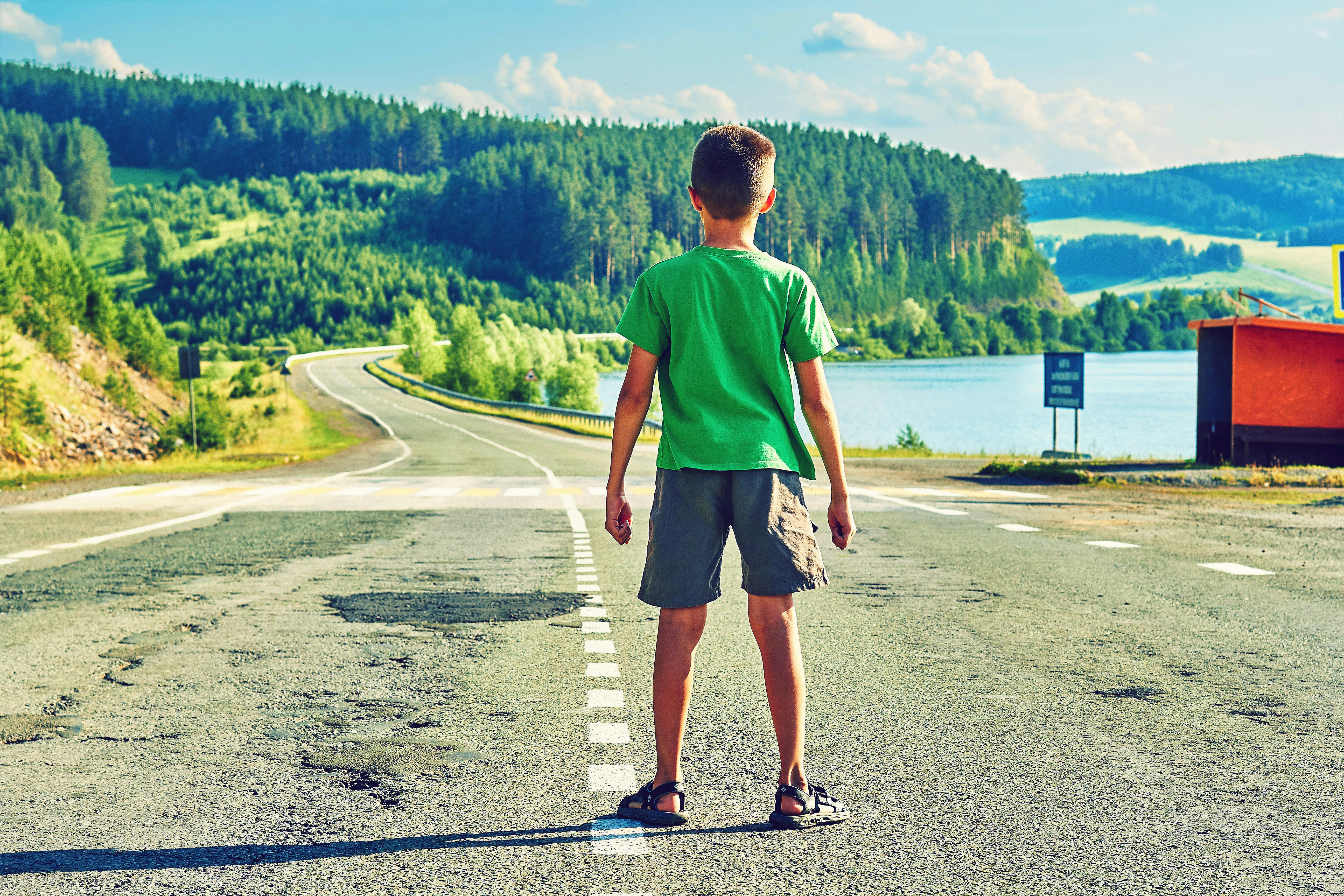A Boy in Green Shirt Standing on the Road · Free Stock Photo
