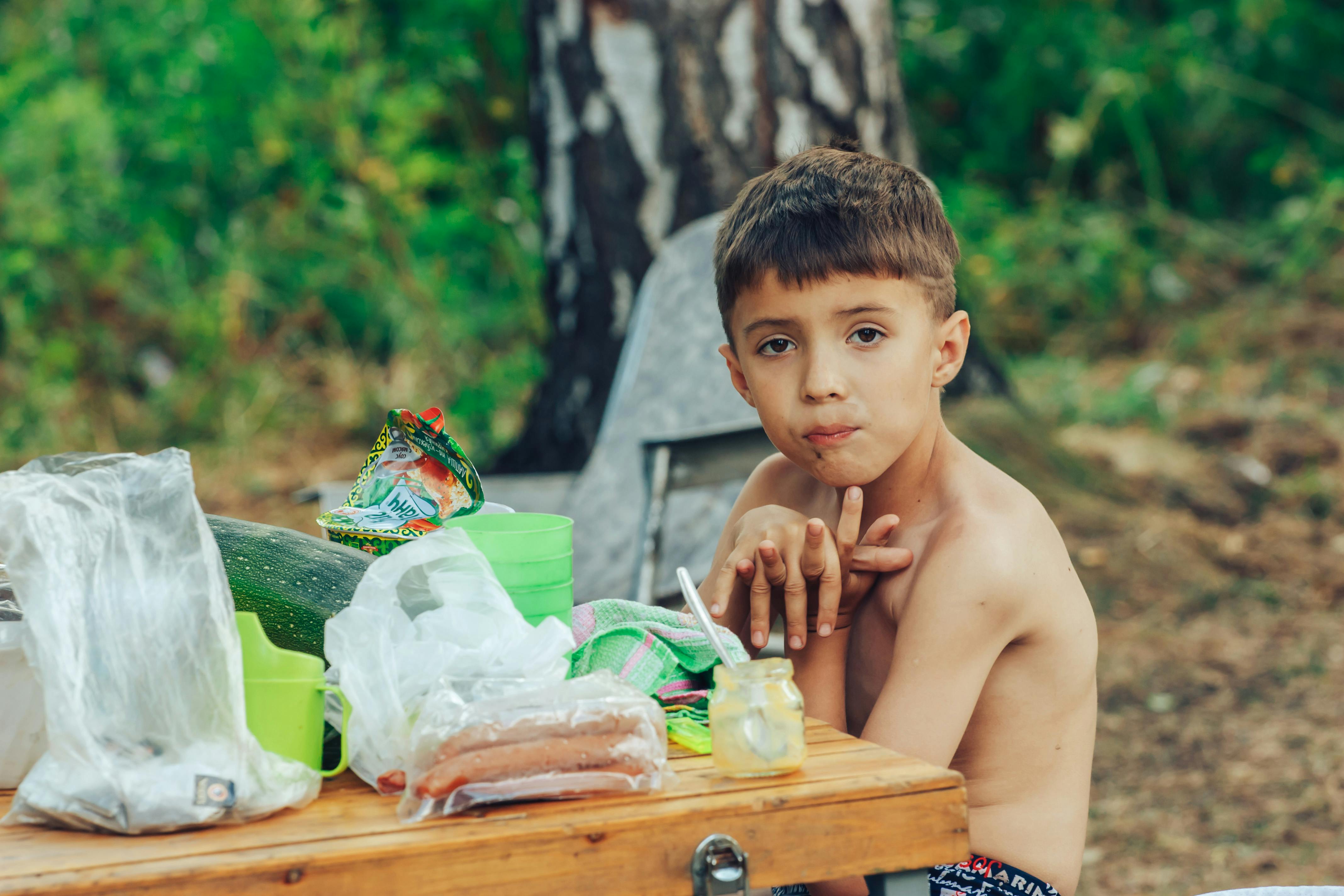 Shirtless Kid Sitting with Hands Clasped · Free Stock Photo
