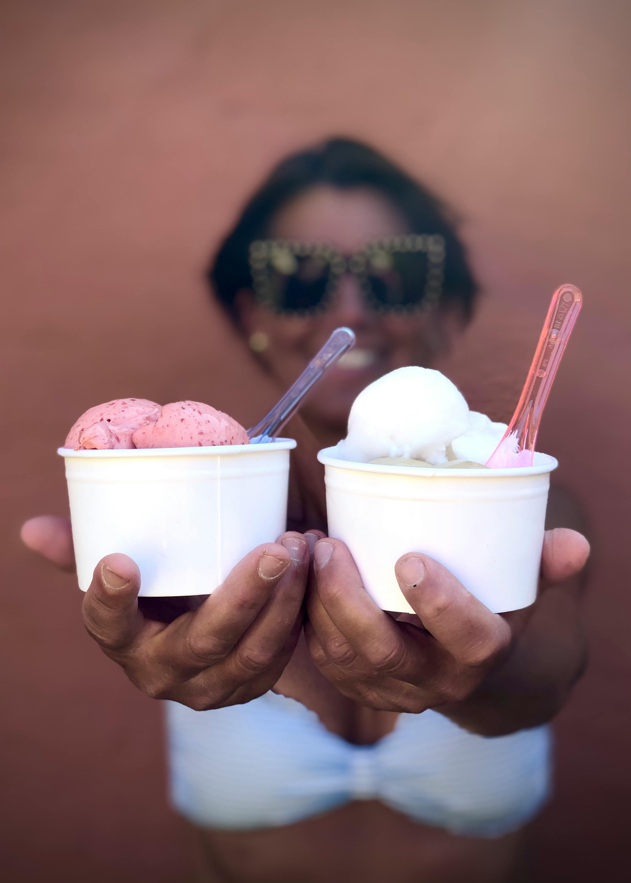 A Person Holding a Cup of Ice Cream in the Street · Free Stock Photo