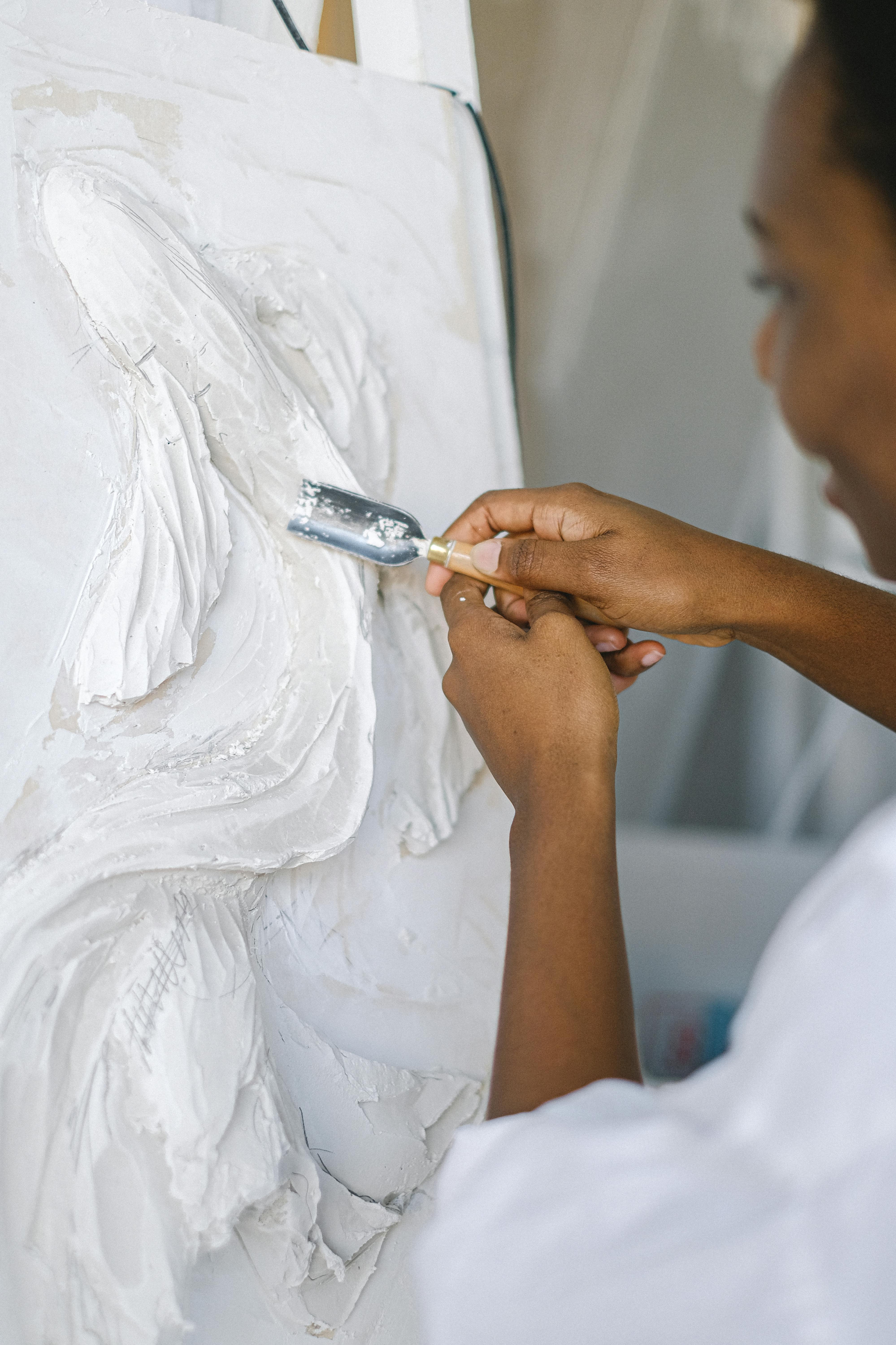 Woman Using a Chisel on an Artwork · Free Stock Photo