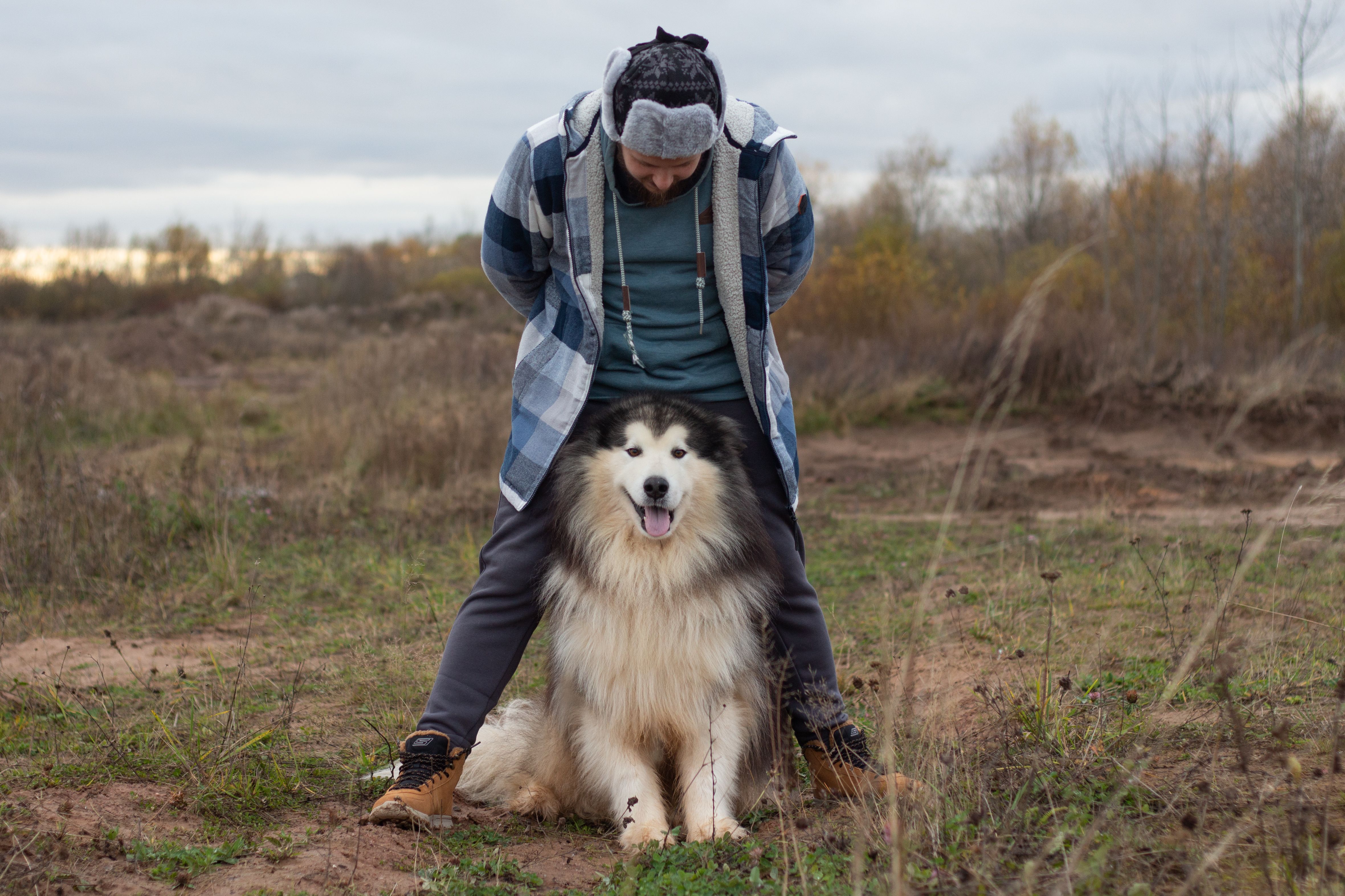 Man in Blue Checkered Jacket Standing Behind his Dog · Free Stock Photo