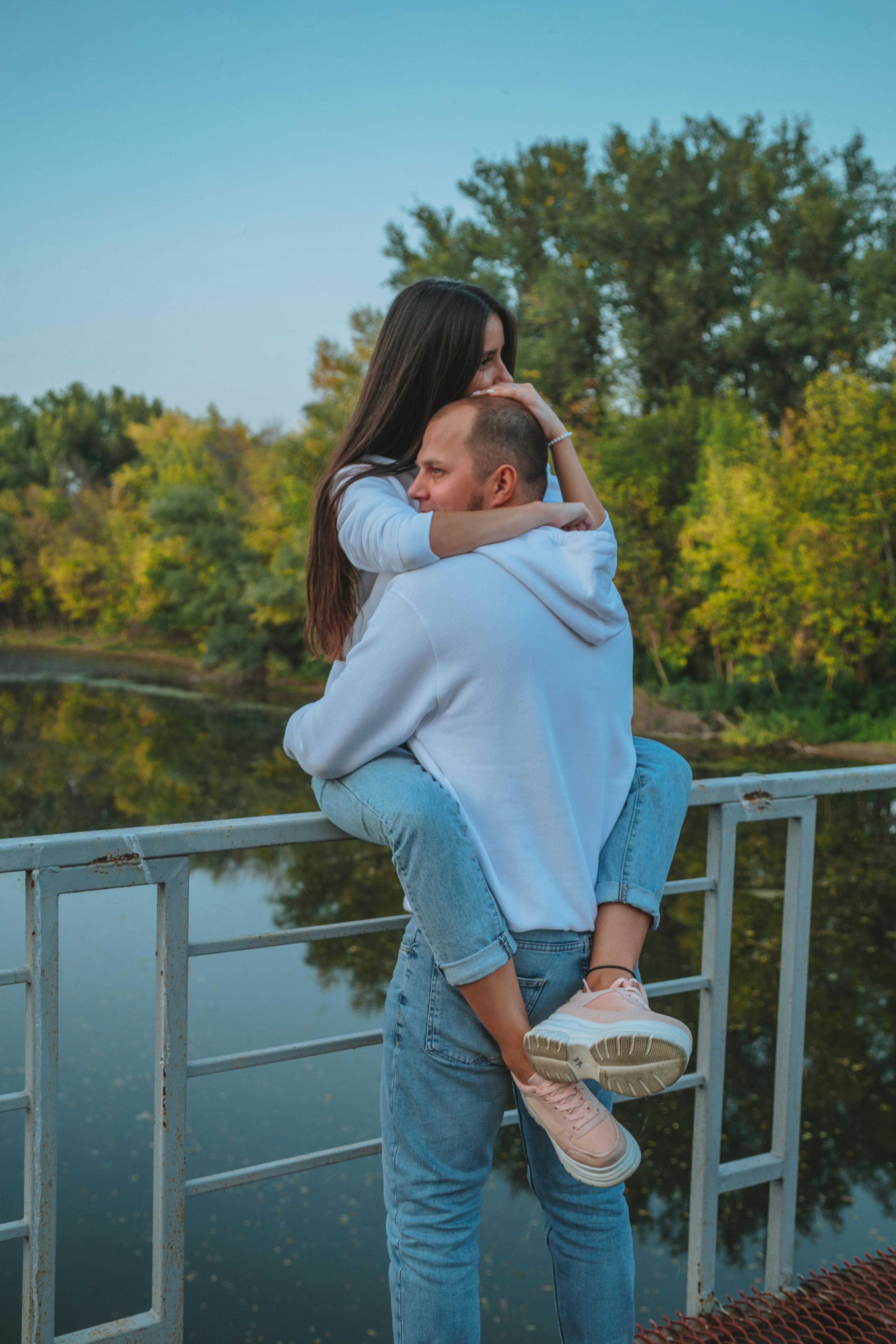 Man hugging Woman seated on Metal Railings · Free Stock Photo