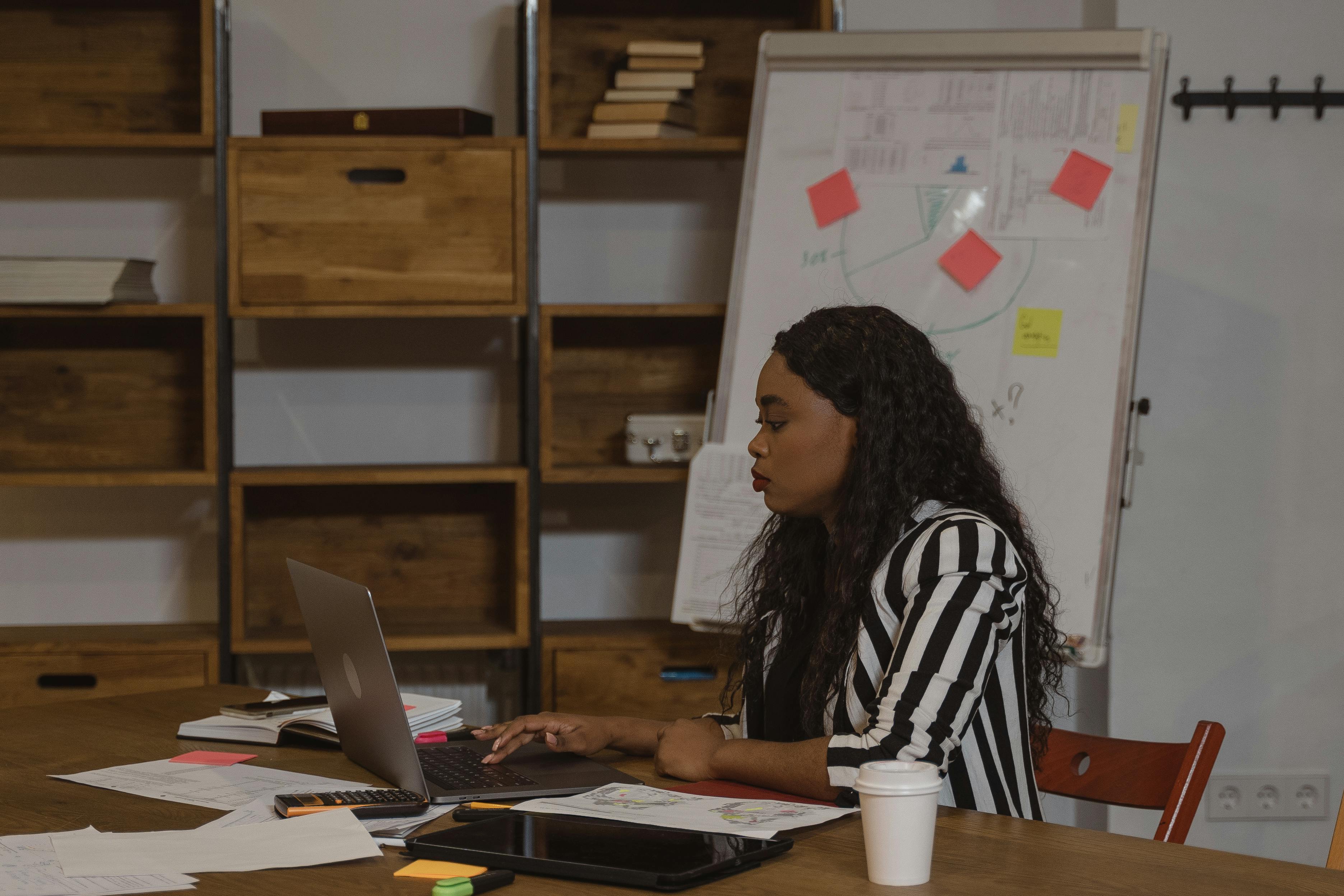 Woman in Stripe Blazer Using Laptop · Free Stock Photo
