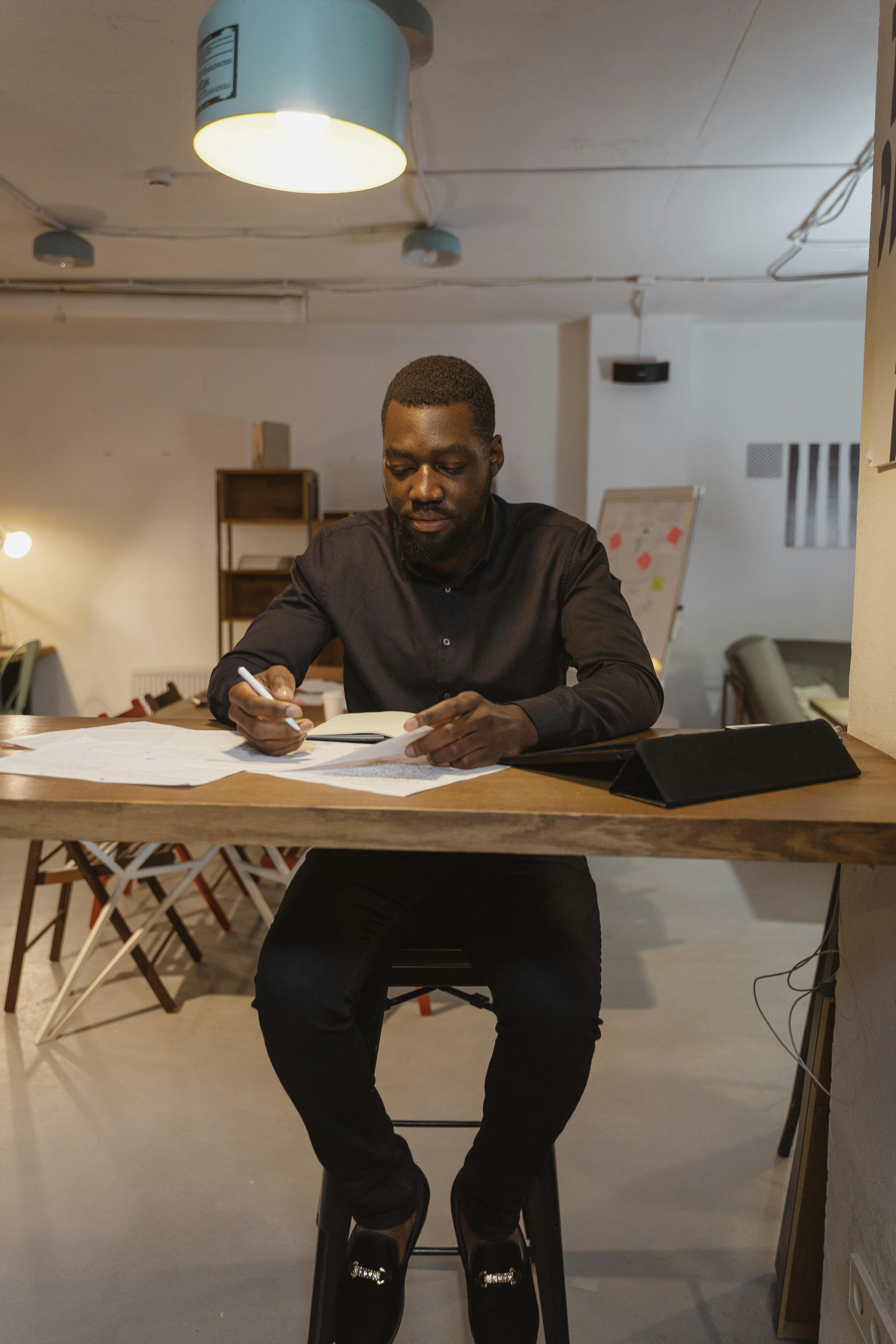 Photo of a Man in a Black Shirt Working while Sitting · Free Stock Photo