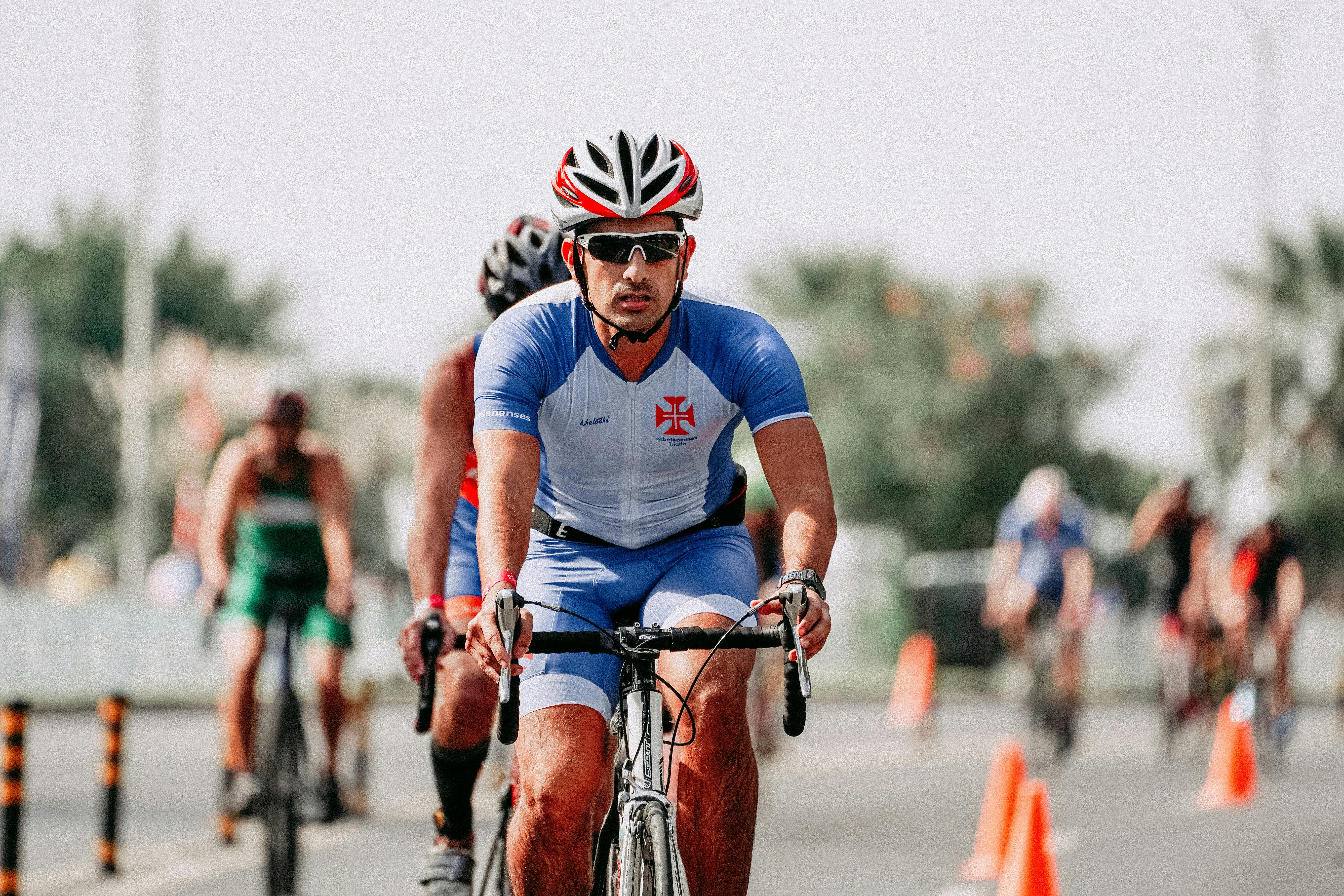 Smiling muscular cyclist riding bike during race on road · Free Stock Photo