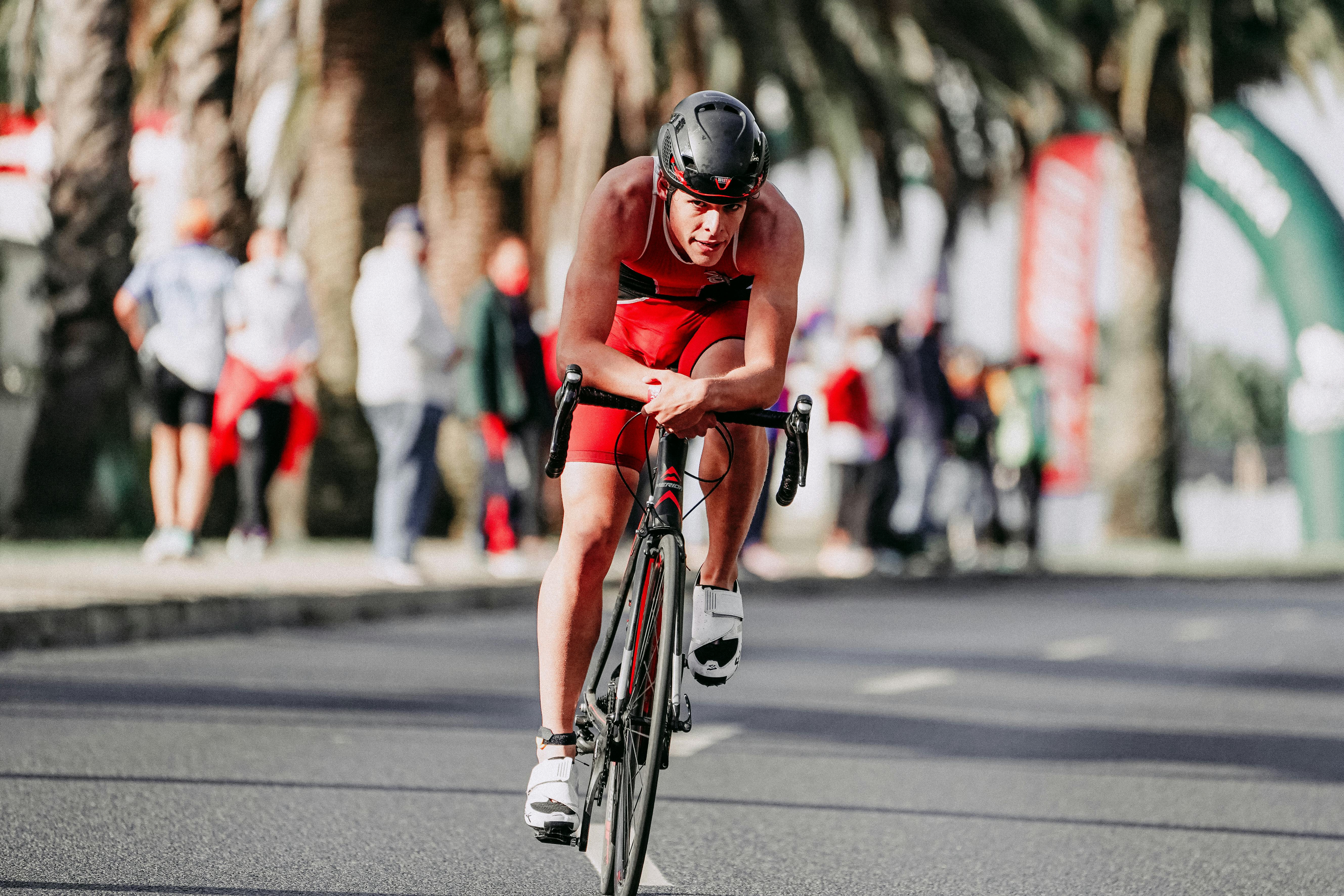 Muscular cyclist riding bike on street · Free Stock Photo