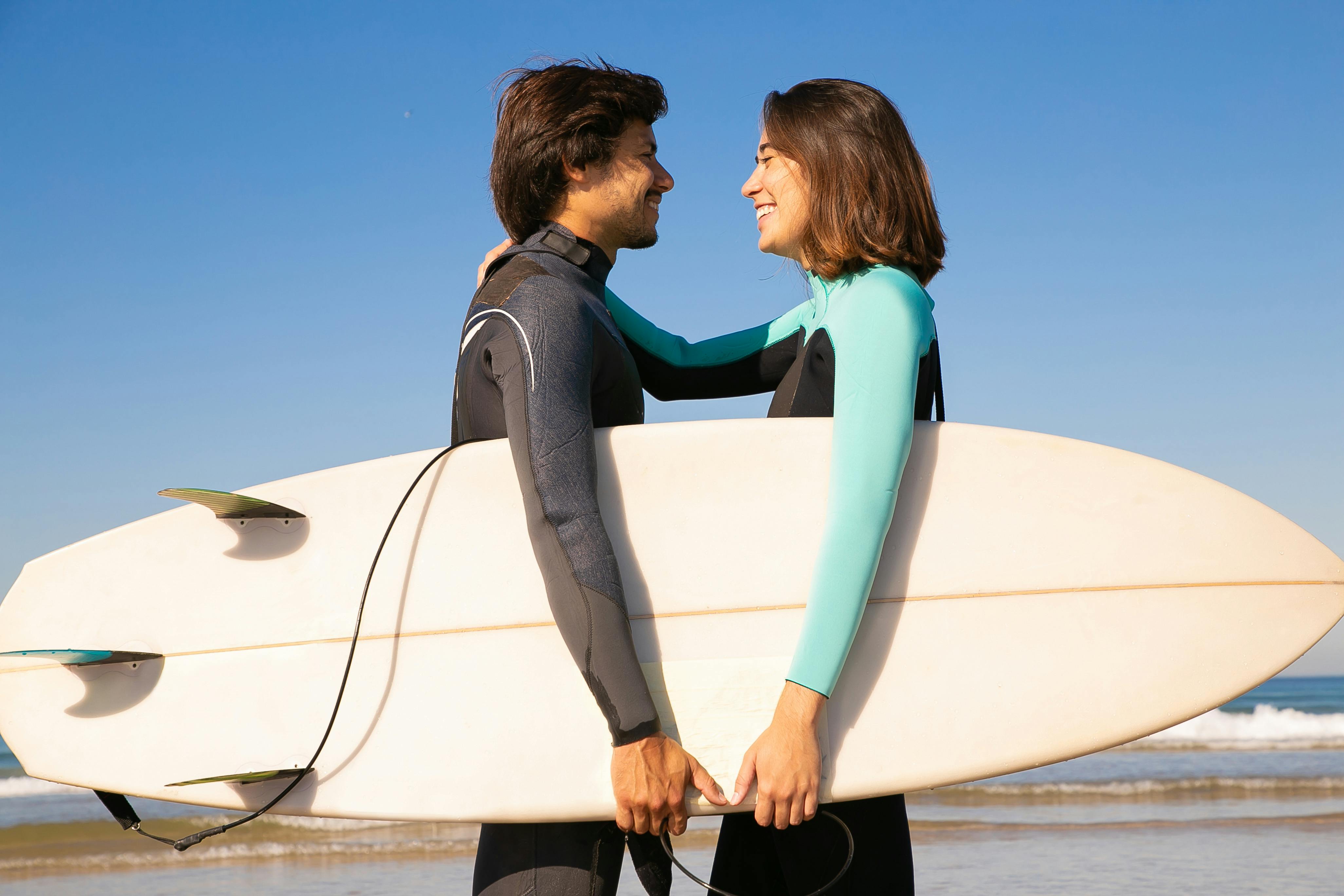 A Happy Surfer Couple Smiling at Each Other · Free Stock Photo
