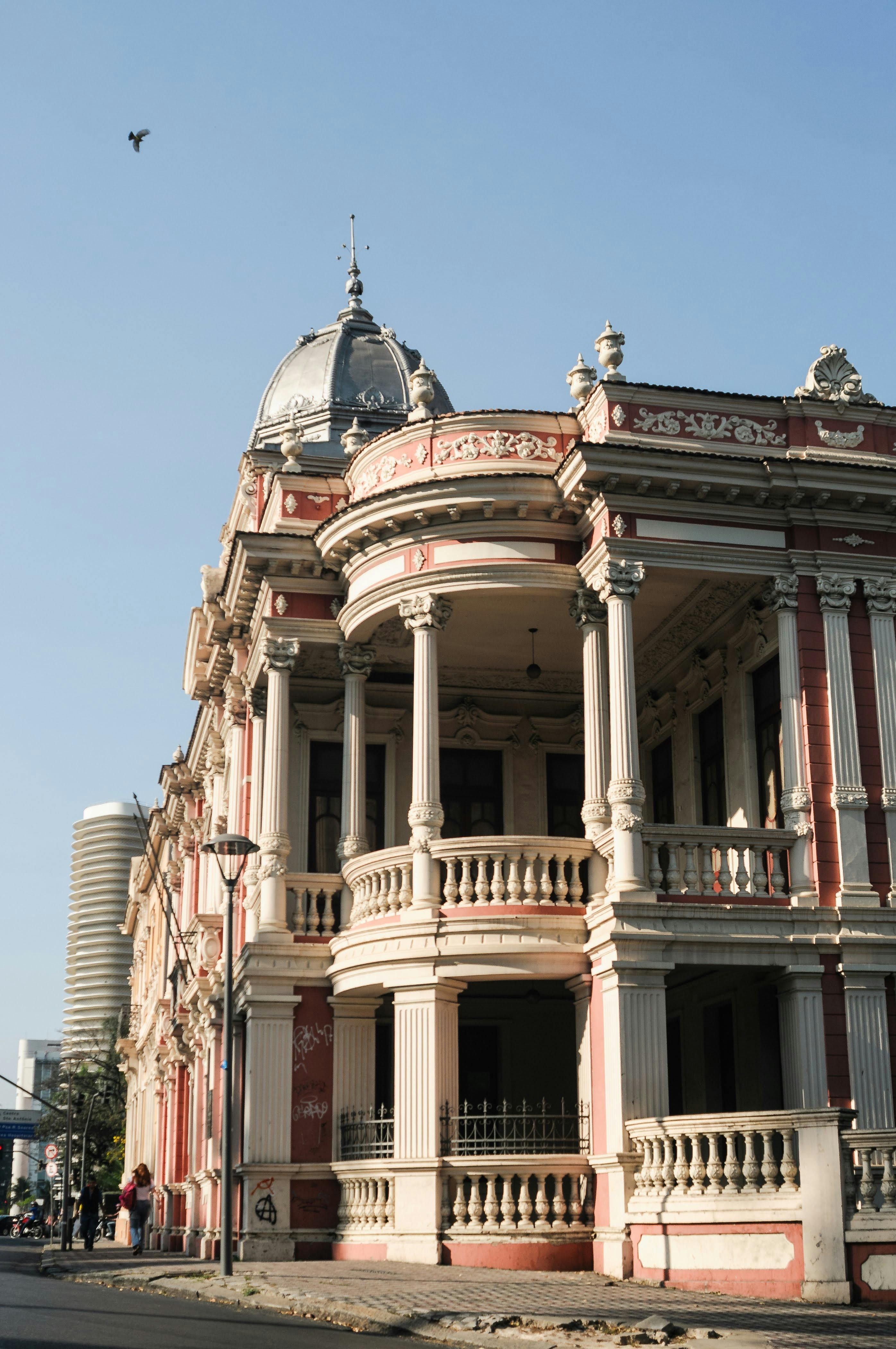 Old building with balconies and arched passage · Free Stock Photo