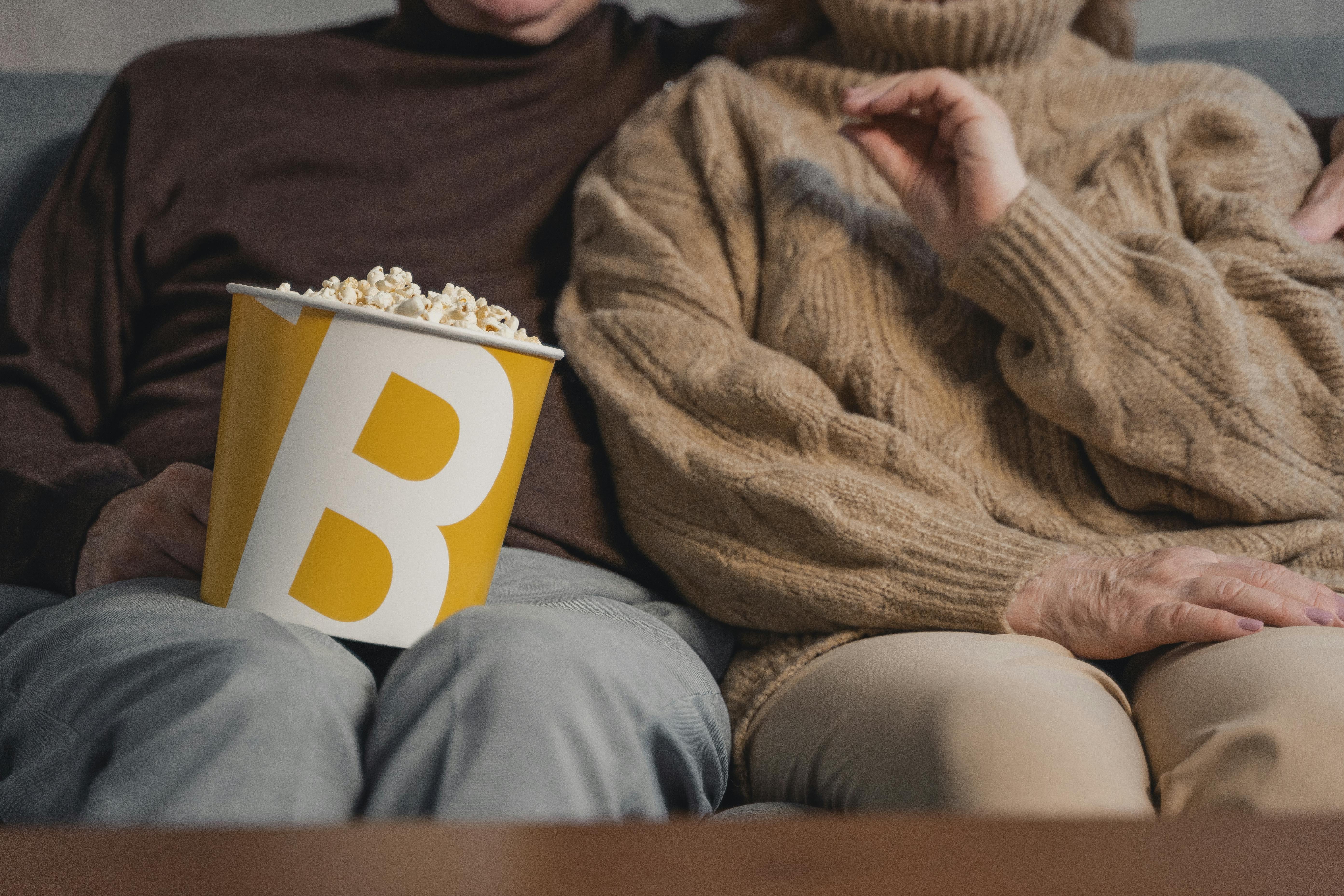 Couple In Brown Jackets with Popcorn on Lap · Free Stock Photo