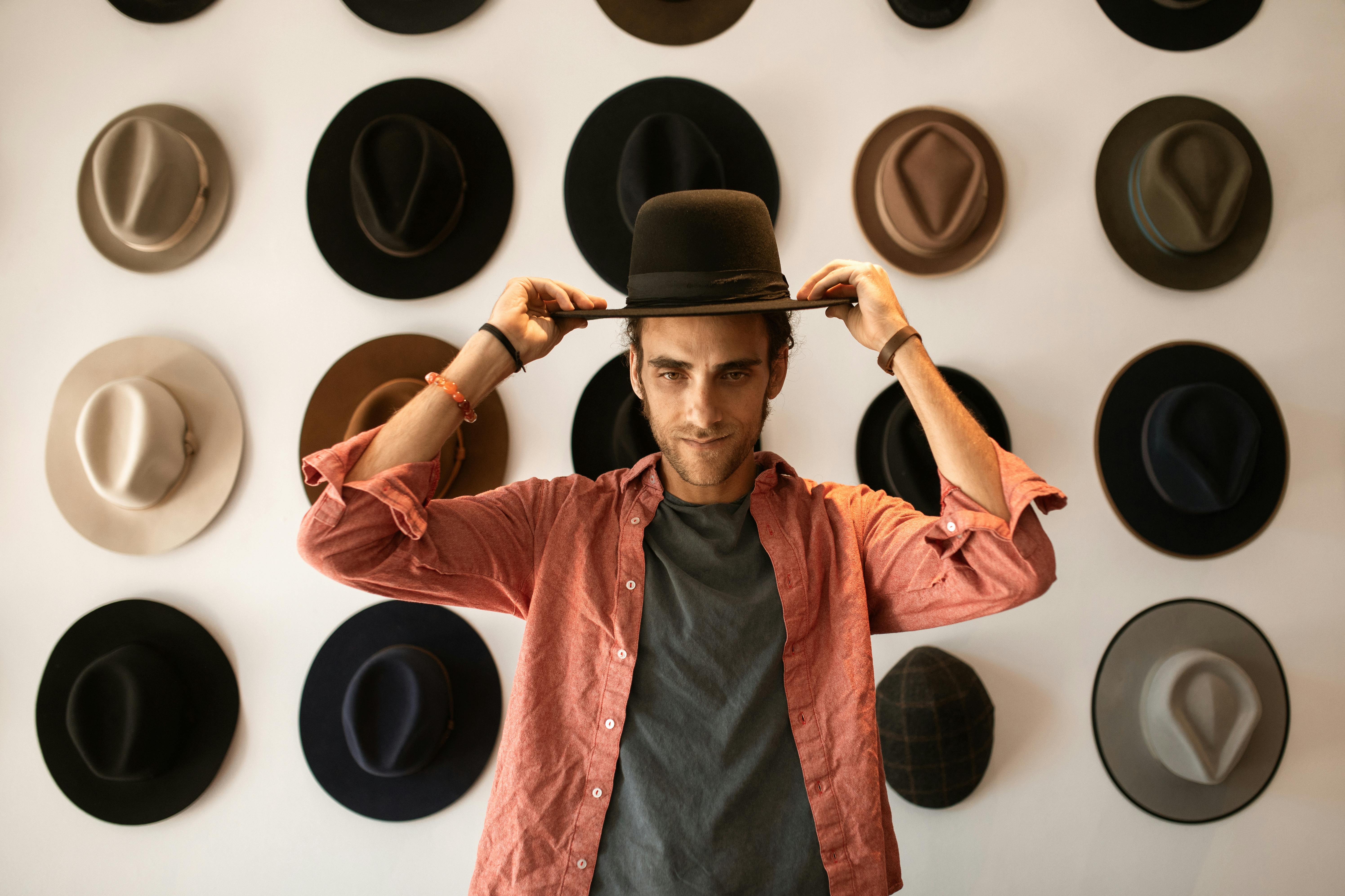 Portrait of Man in Shirt and with Hats behind · Free Stock Photo