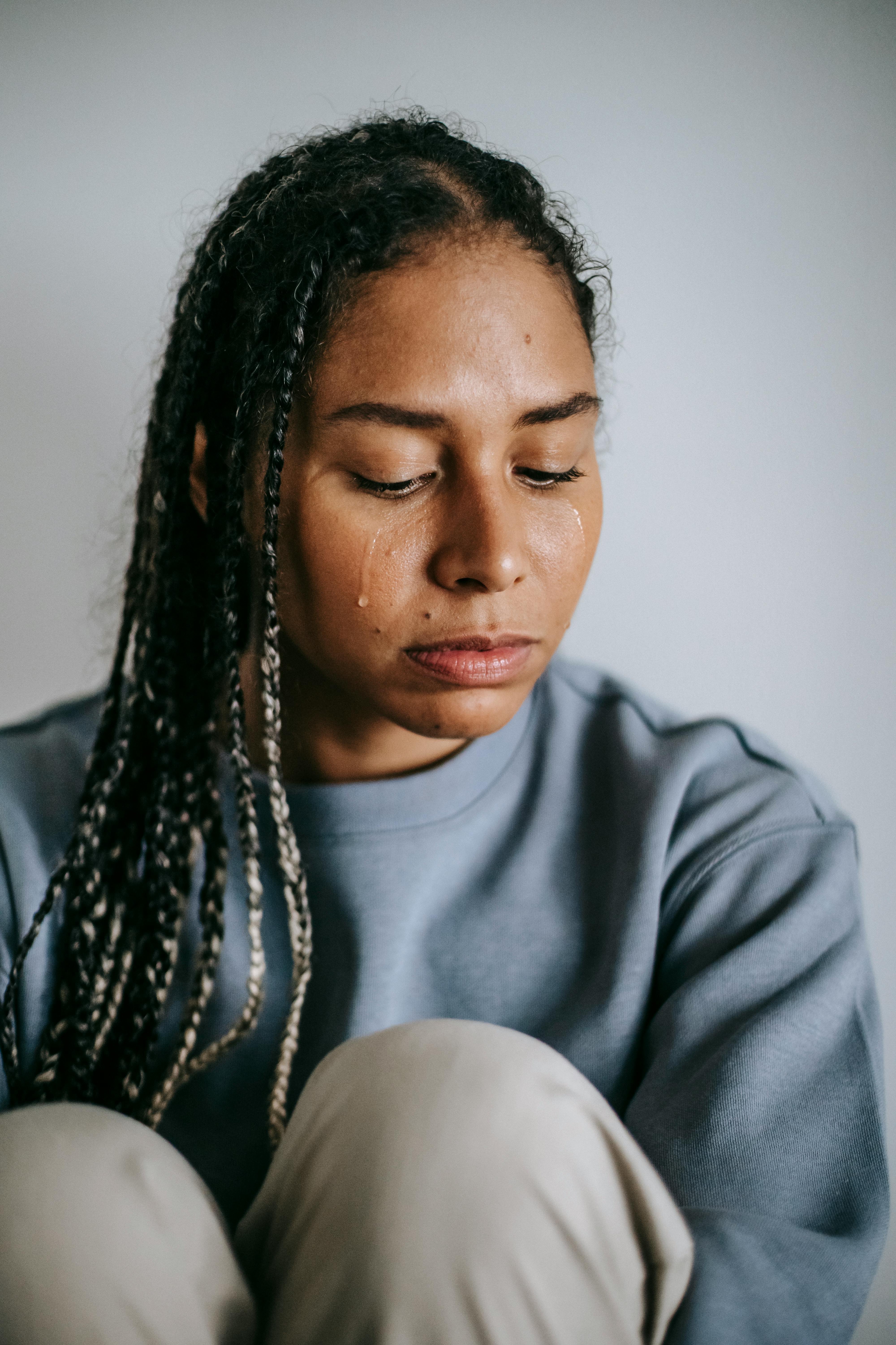 Crying black woman resting on light background · Free Stock Photo