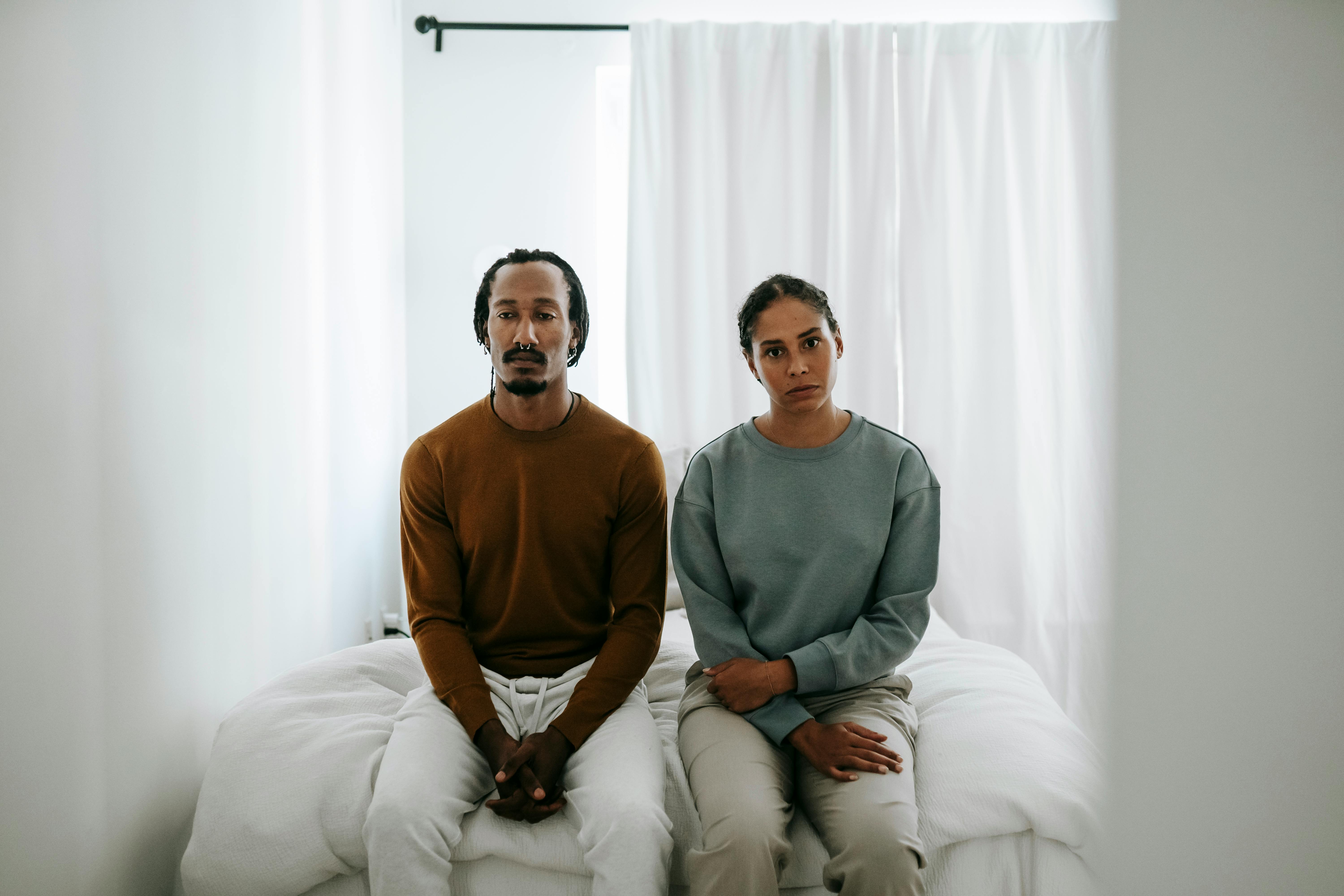 Discontented black couple during conflict on bed at home · Free Stock Photo