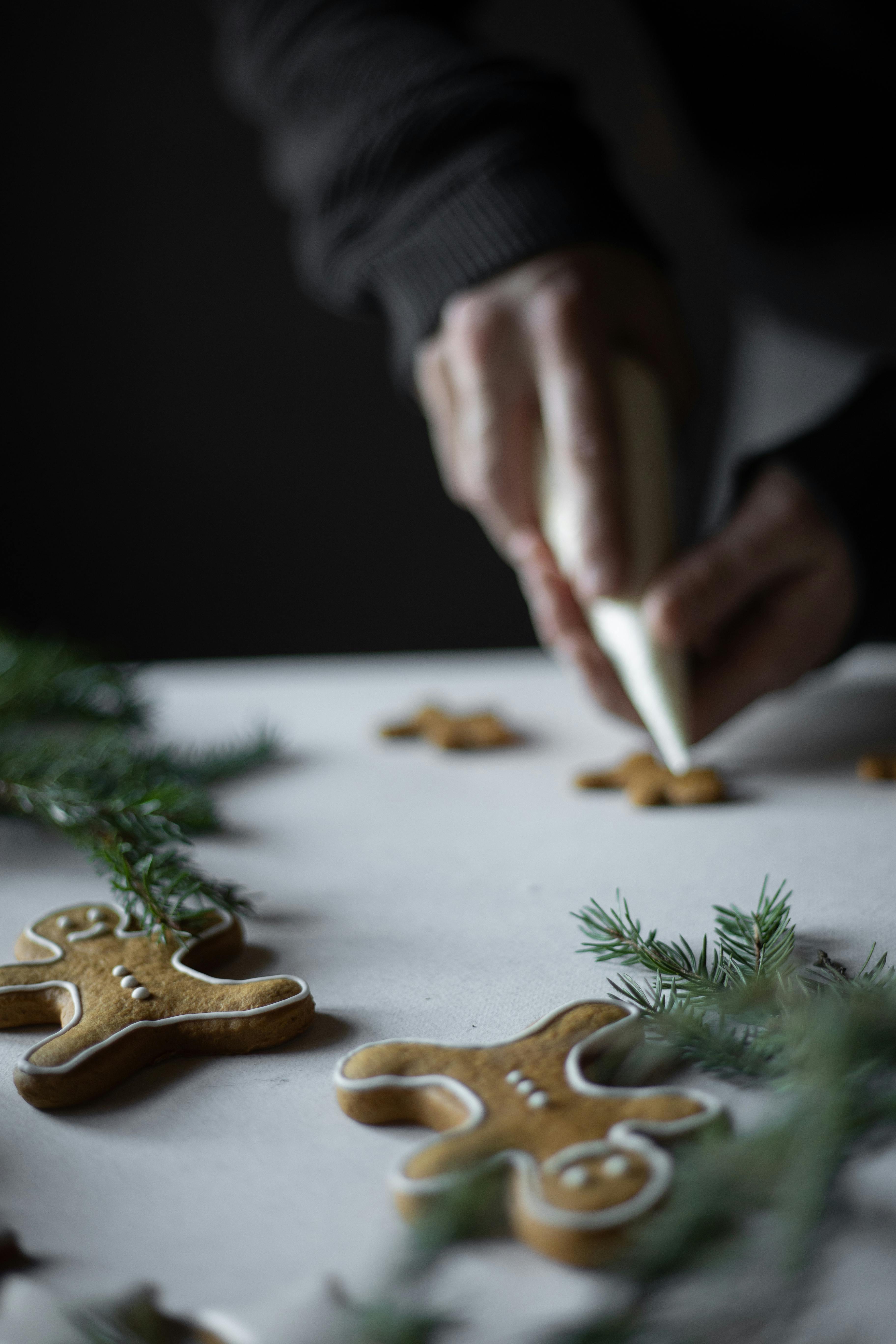 Person Piping Icing on Gingerbread Cookie · Free Stock Photo