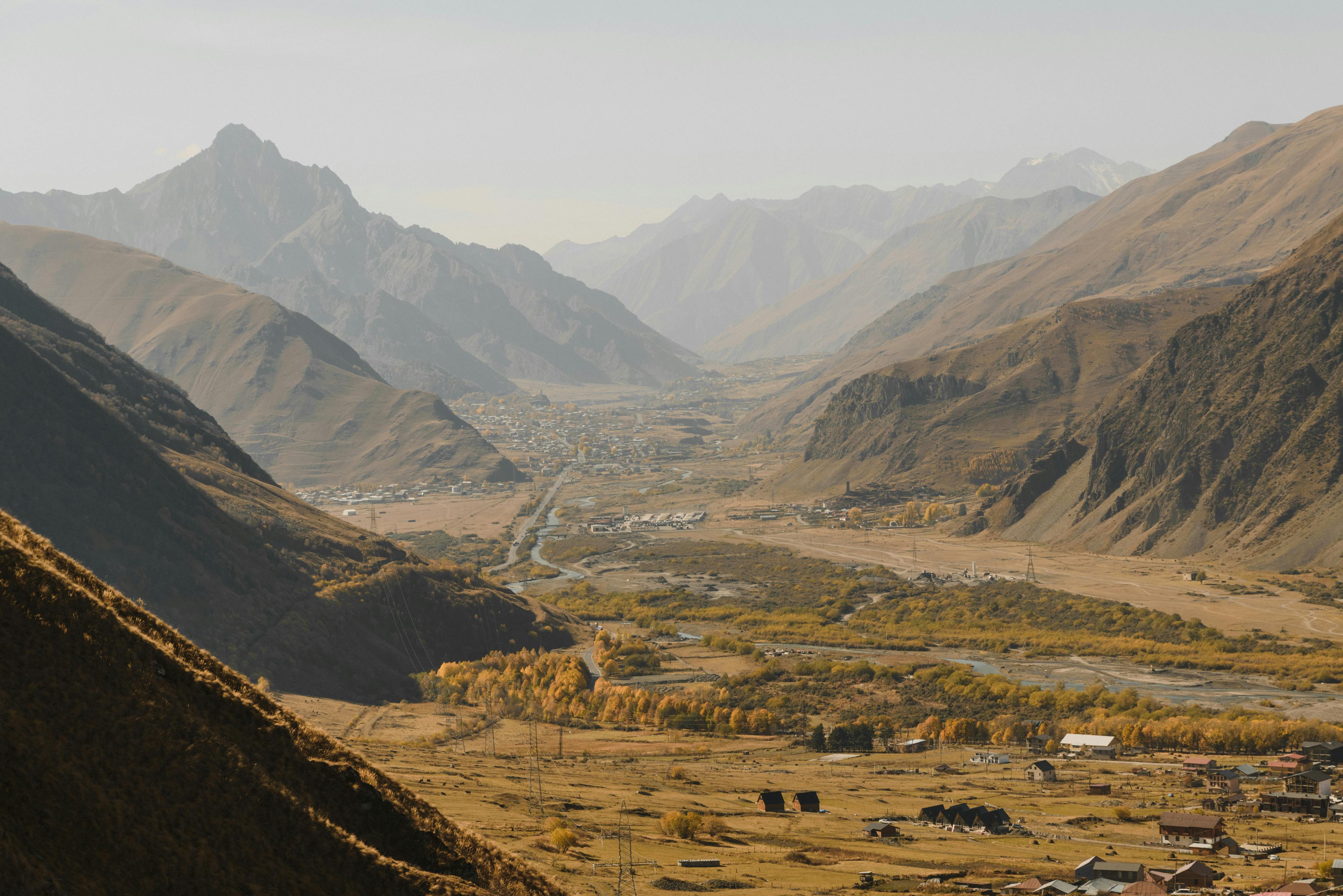 Beige Landscape with Rocky Mountains and Village in a Barren Valley ...
