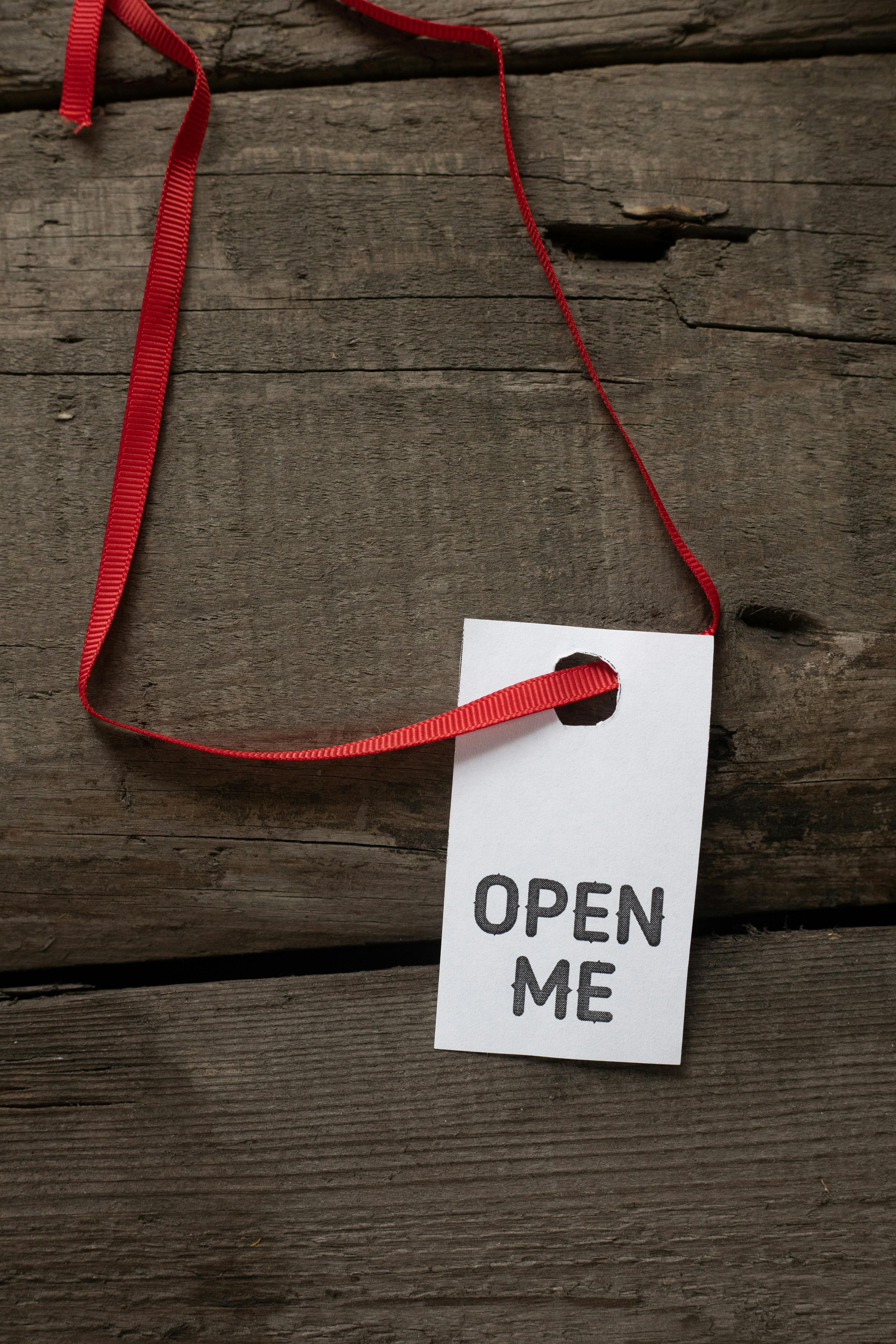 Present box with Open Me inscription on tag · Free Stock Photo