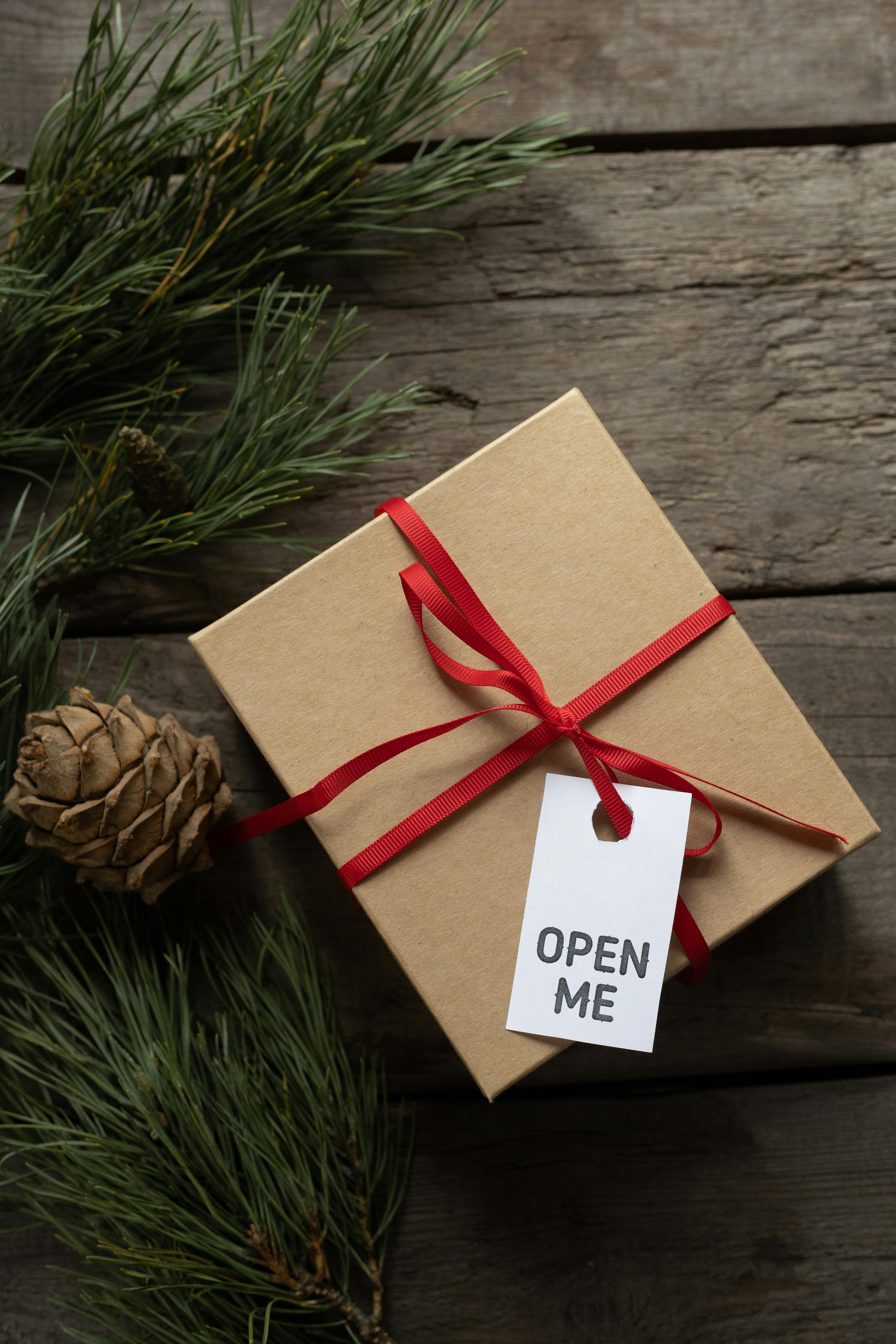 Present box with Open Me inscription on tag · Free Stock Photo