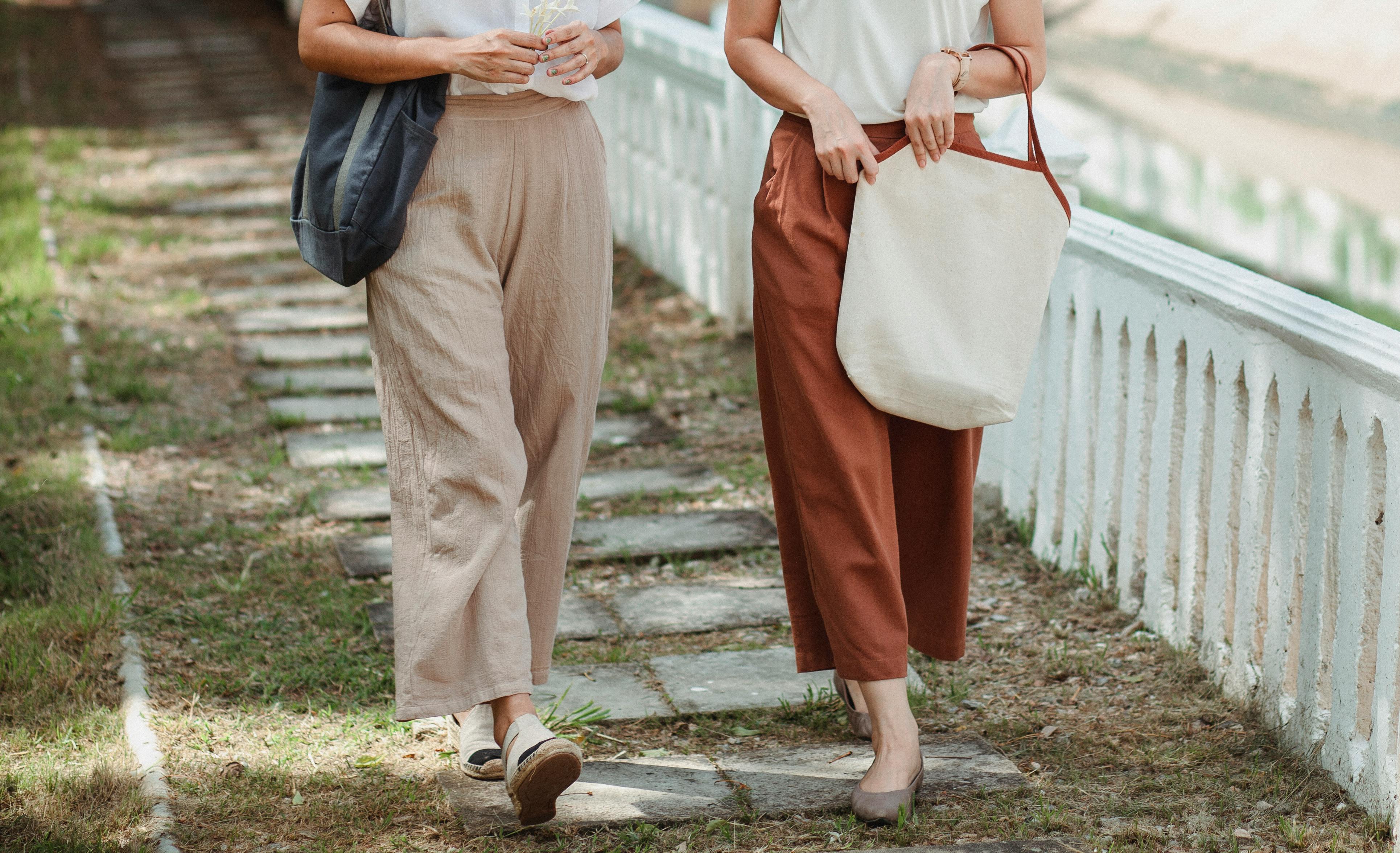 Faceless female friends walking on pathway in city · Free Stock Photo