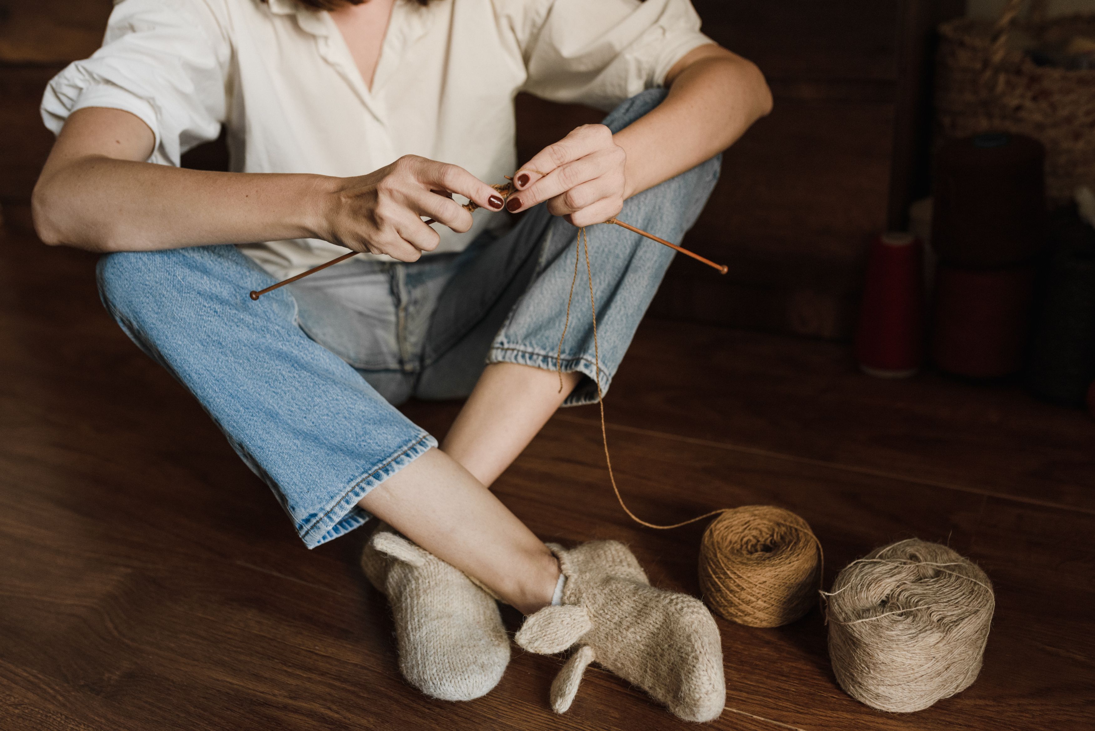 Photo of a Person in Denim Jeans Knitting · Free Stock Photo