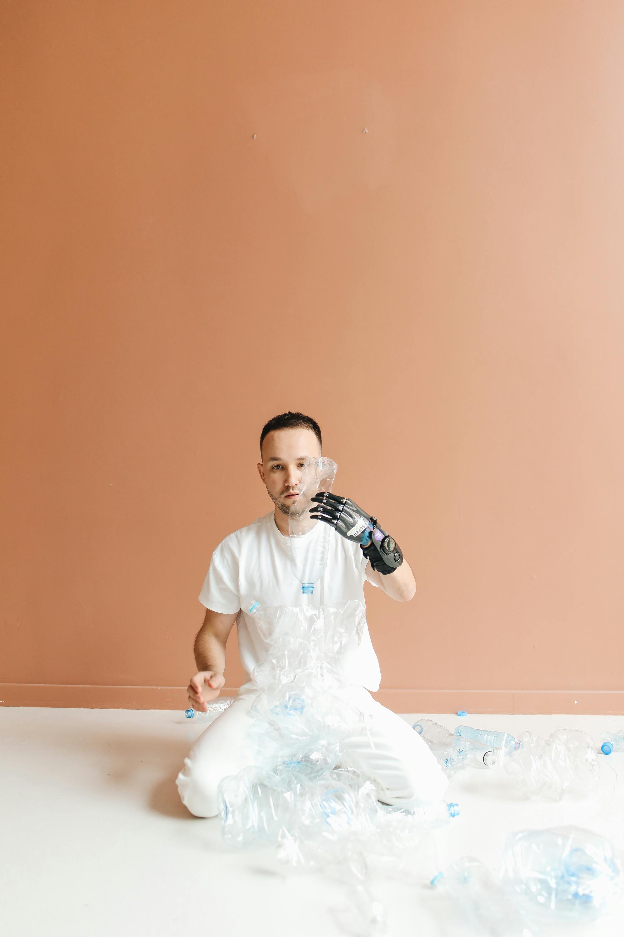 Man Sitting among Plastic Bottles · Free Stock Photo