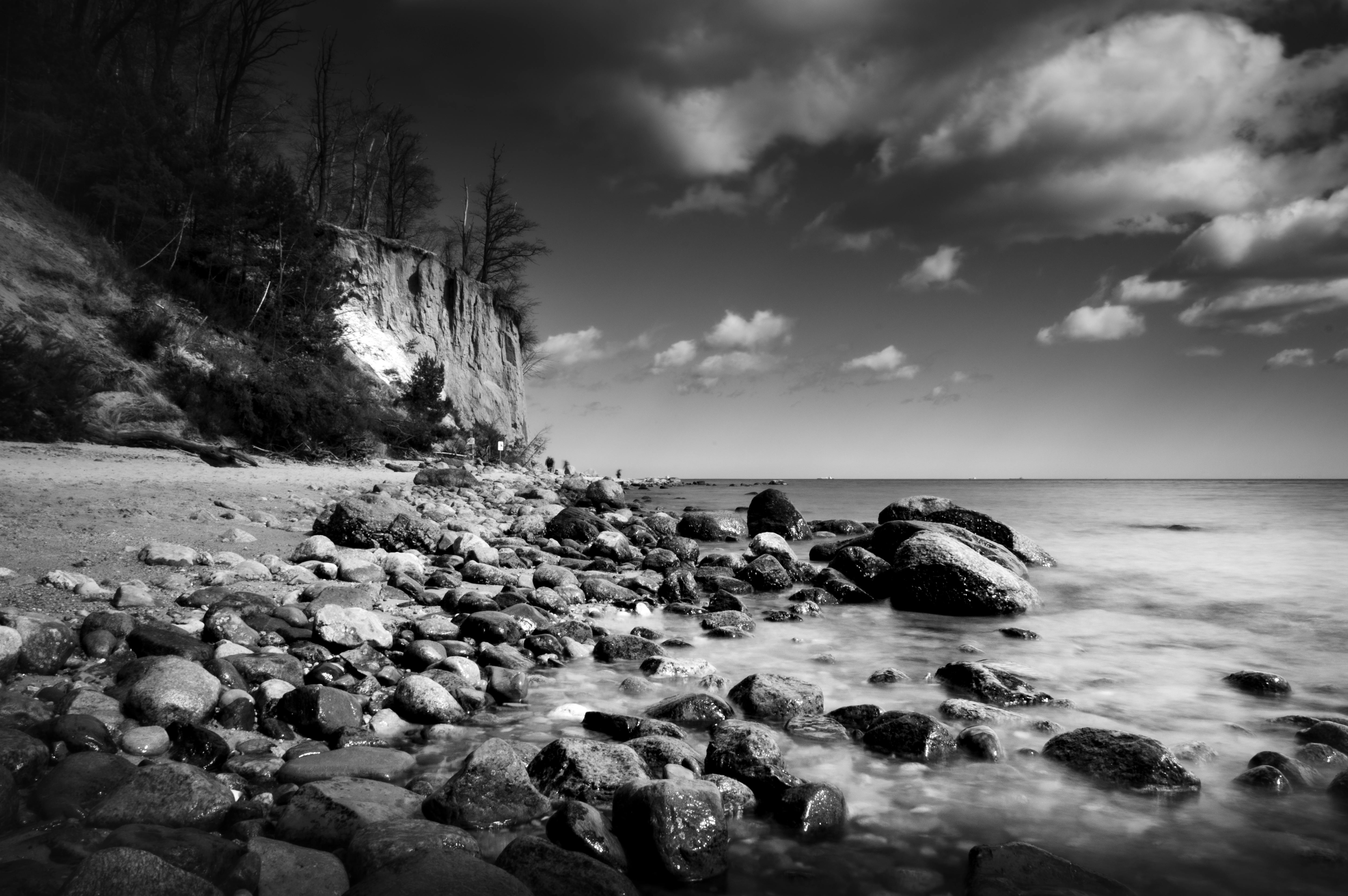 Grayscale Photo of Rocks on Seashore · Free Stock Photo