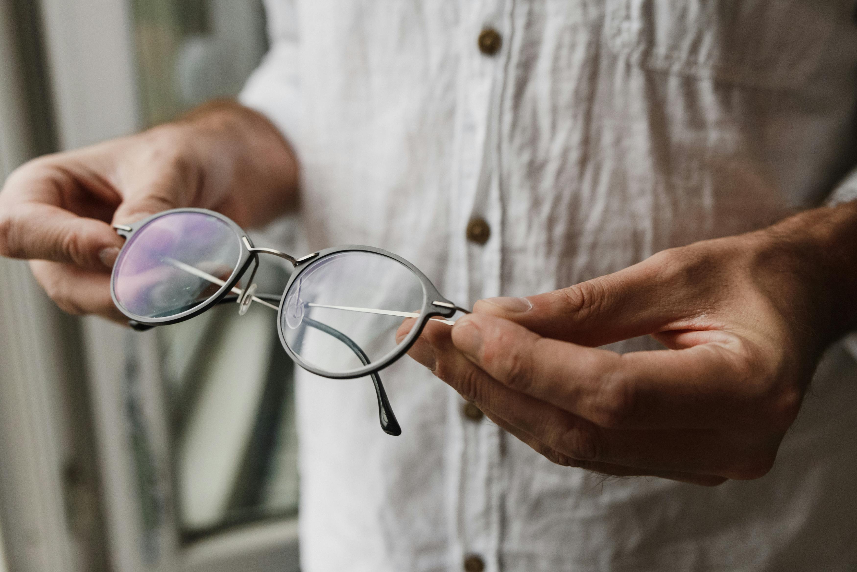 Close-up of Hands of Man Holding Eyeglasses · Free Stock Photo