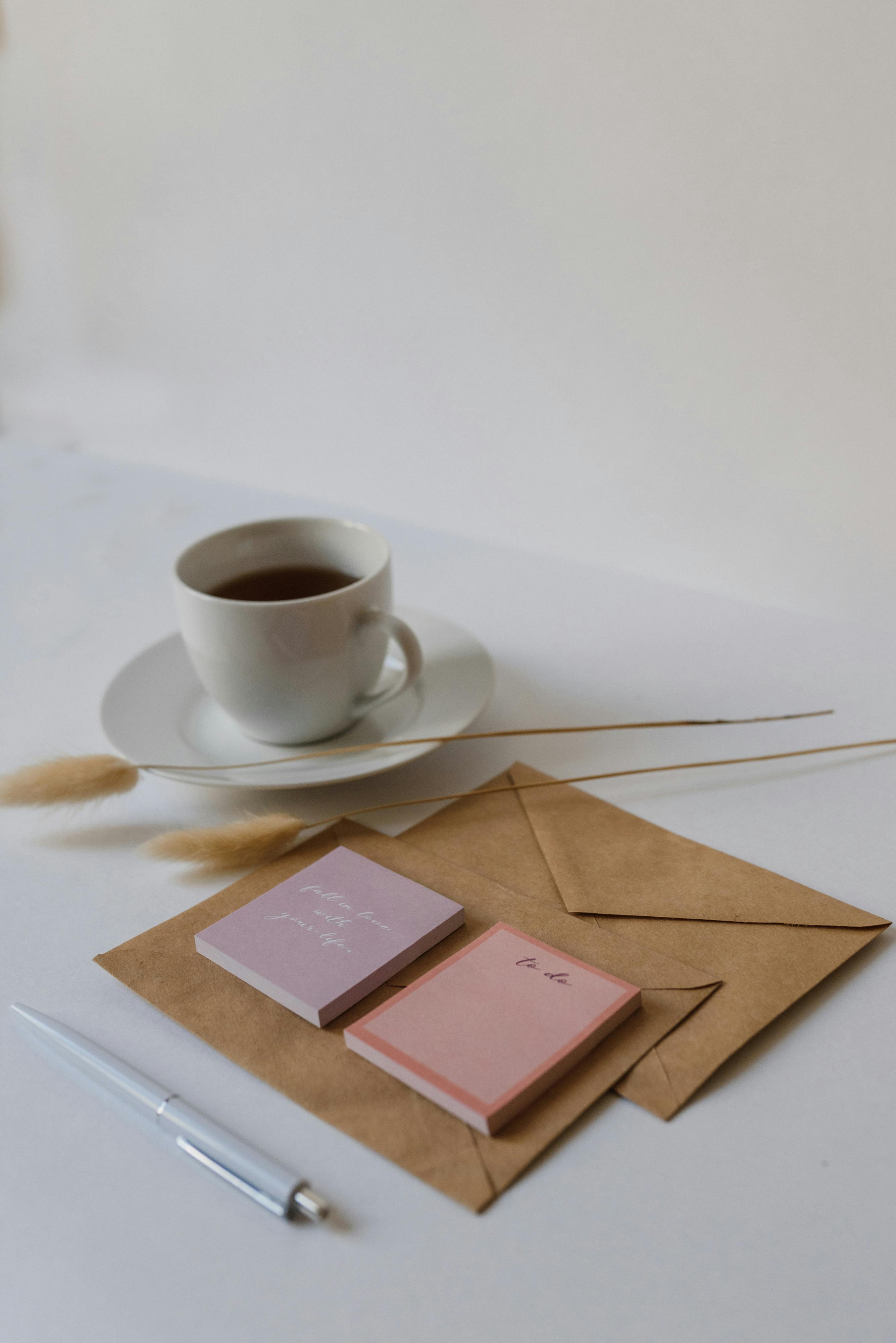 Purple and Pink Paper Sticky Notes on Brown Envelopes Next to a Cup of ...