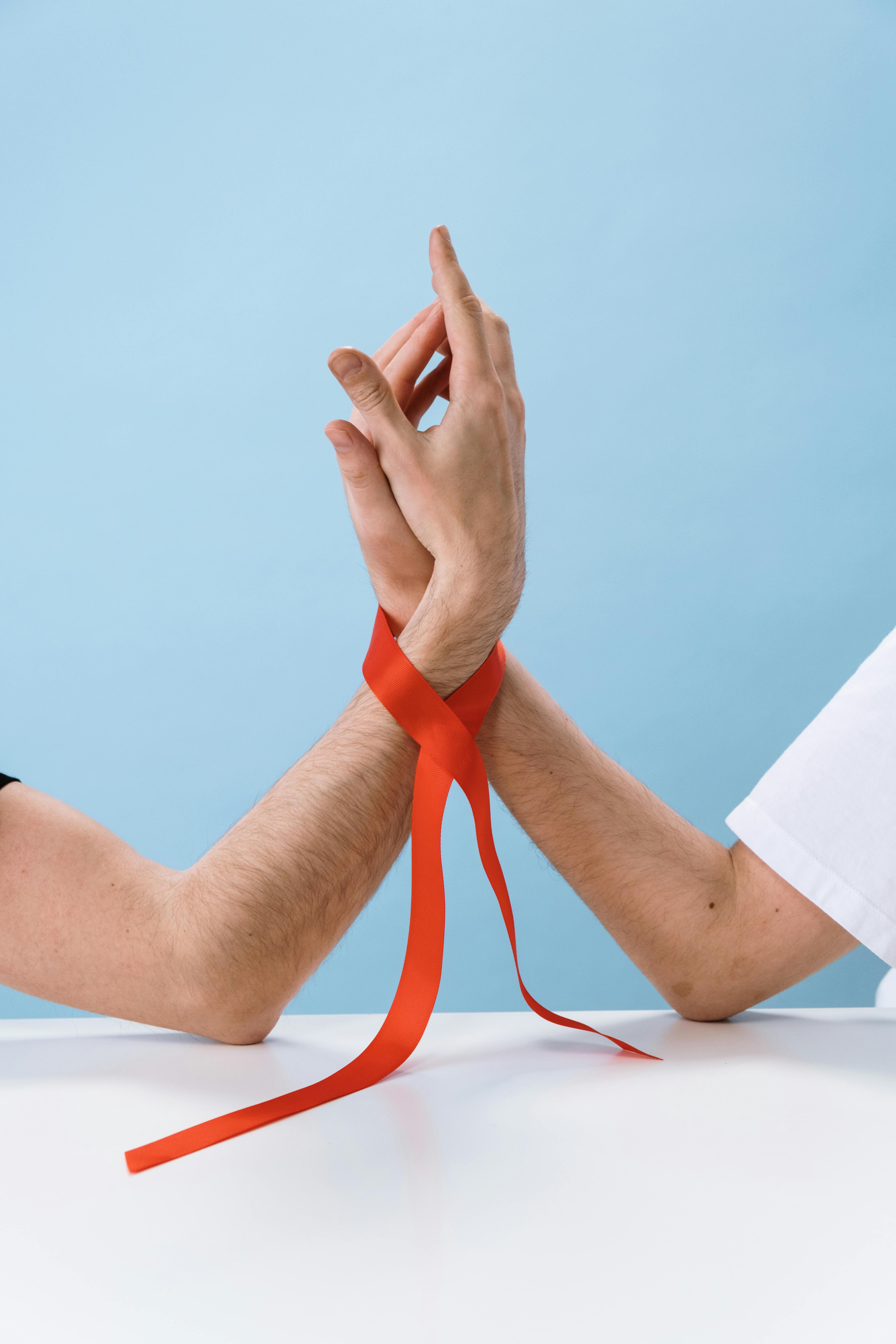 Person Holding Red Ribbon With Bow · Free Stock Photo