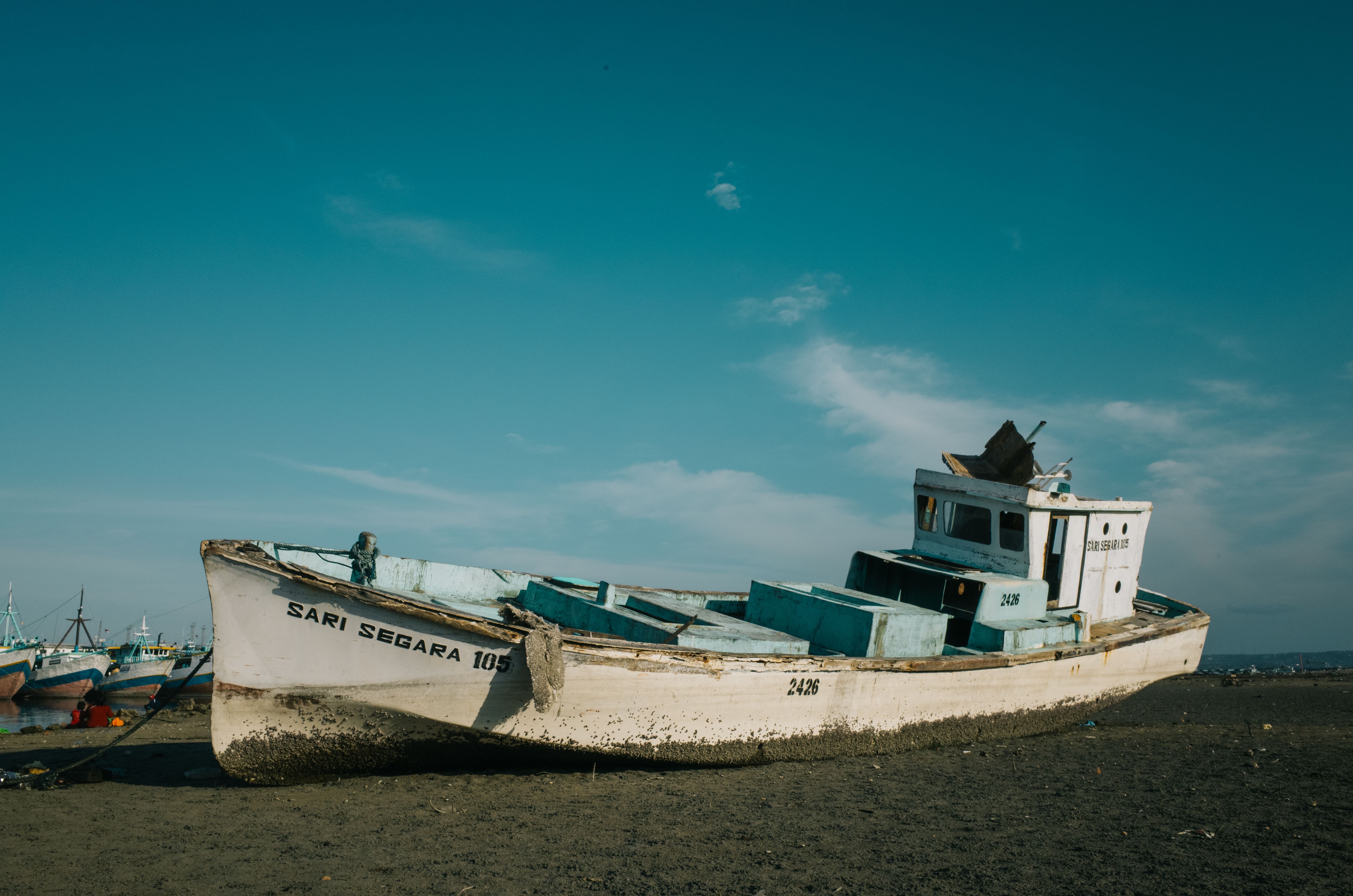 Photo of gray and teal boat on seashore · Free Stock Photo