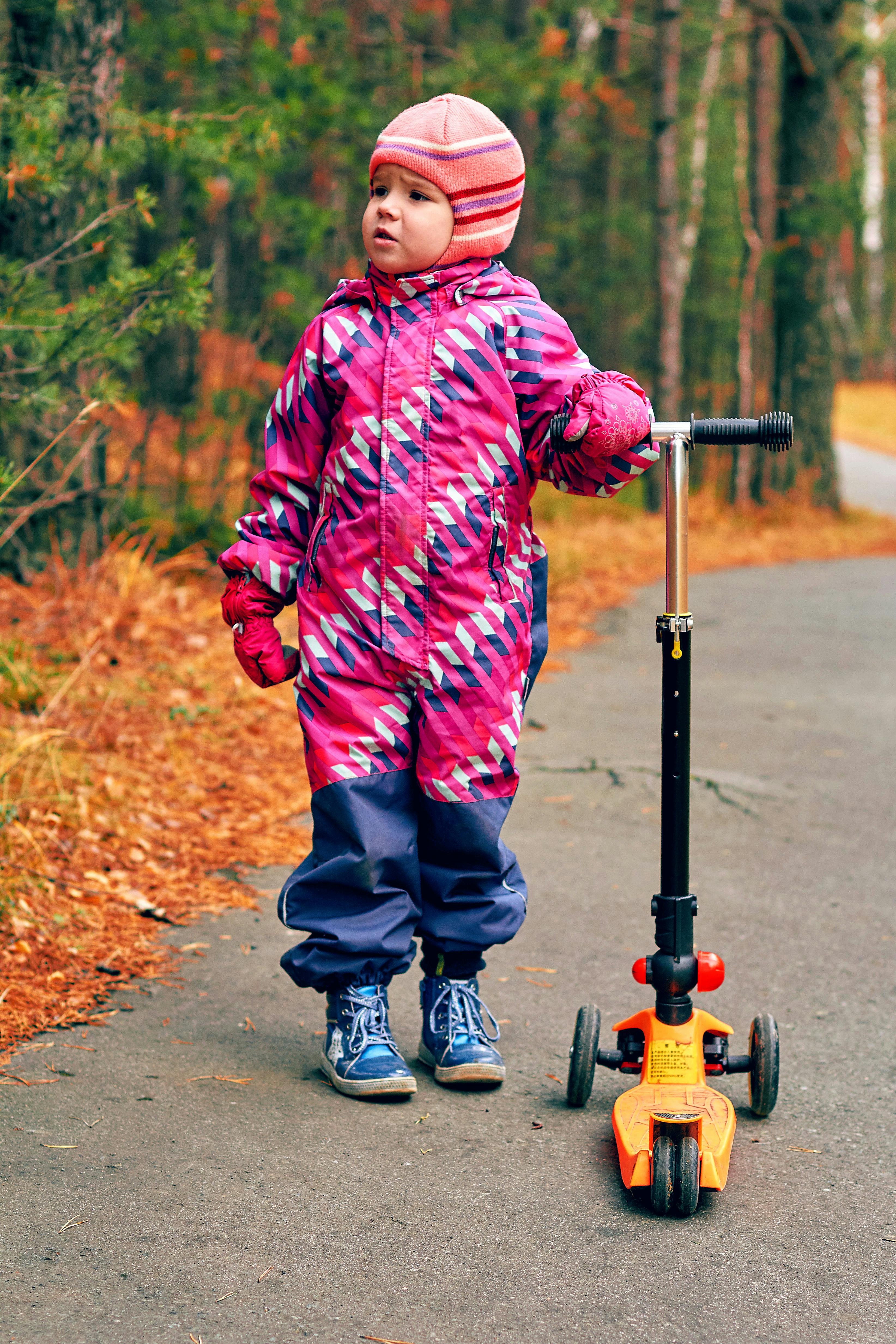 Boy in Pink Overalls with Push Scooter · Free Stock Photo
