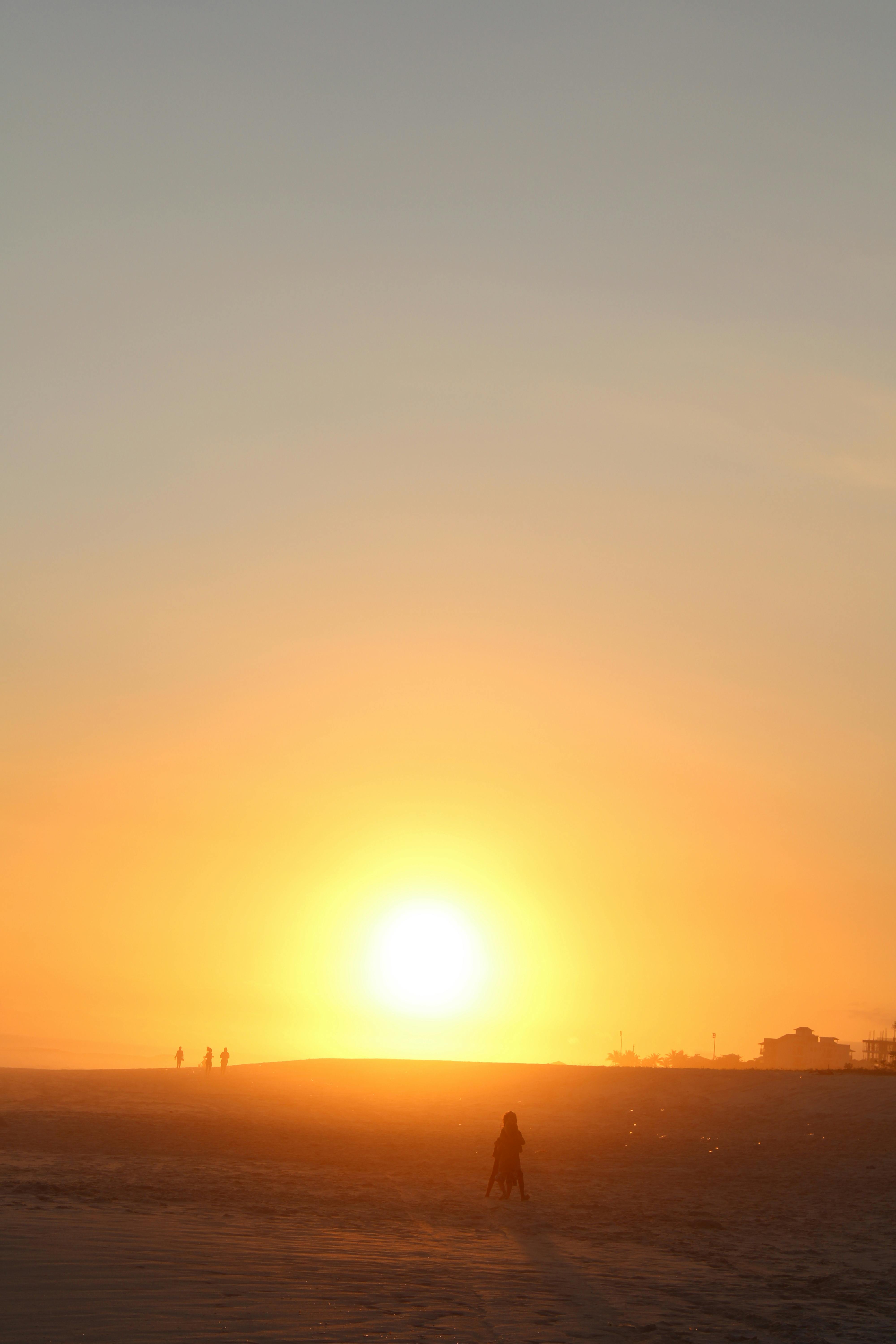 Buildings and Human Silhouettes in Light of Sunset · Free Stock Photo