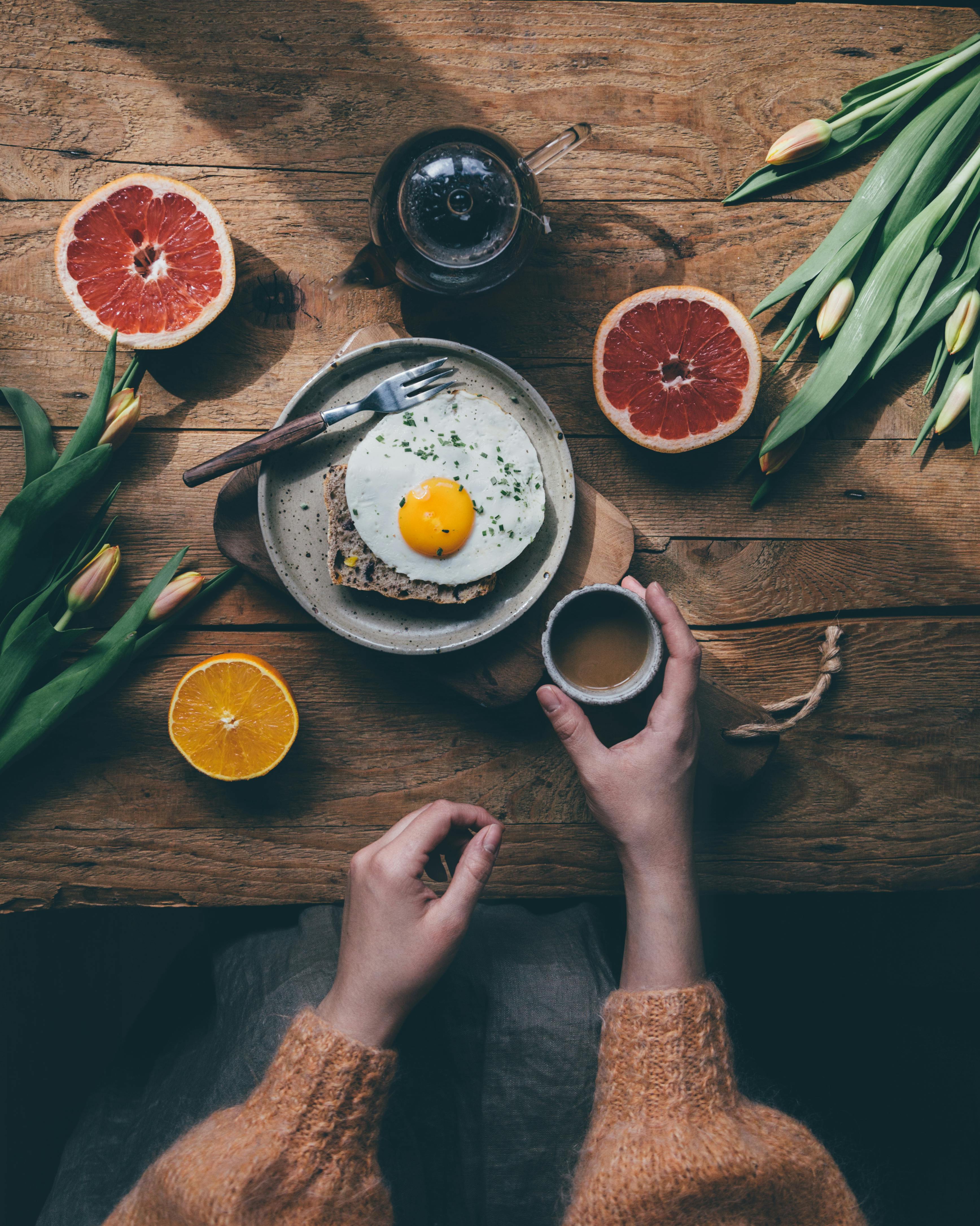 Woman Eating Breakfast and Coffee at Wooden Table · Free Stock Photo