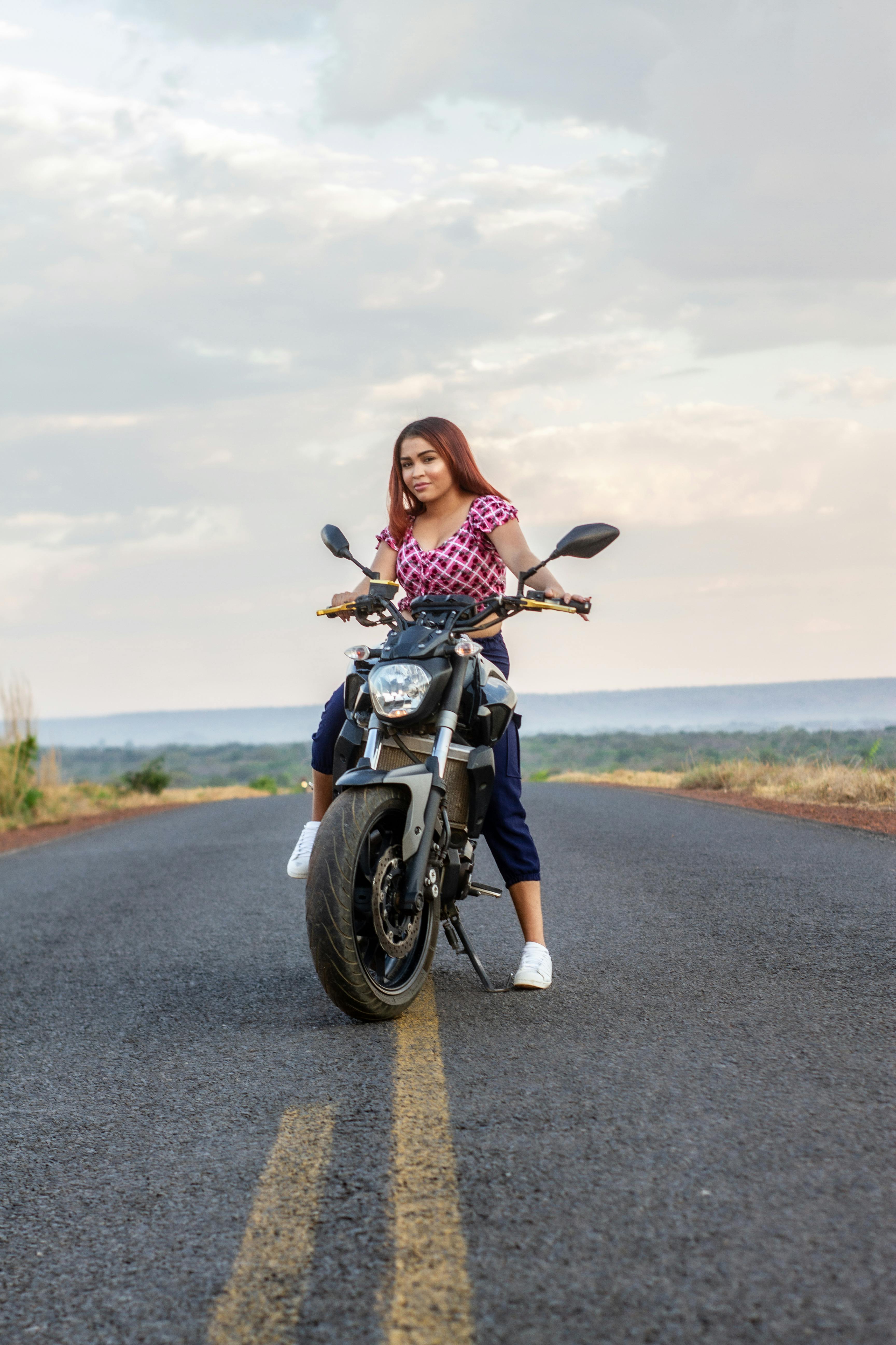 A Woman Riding a Parked Motorcycle in the Middle of the Road · Free ...