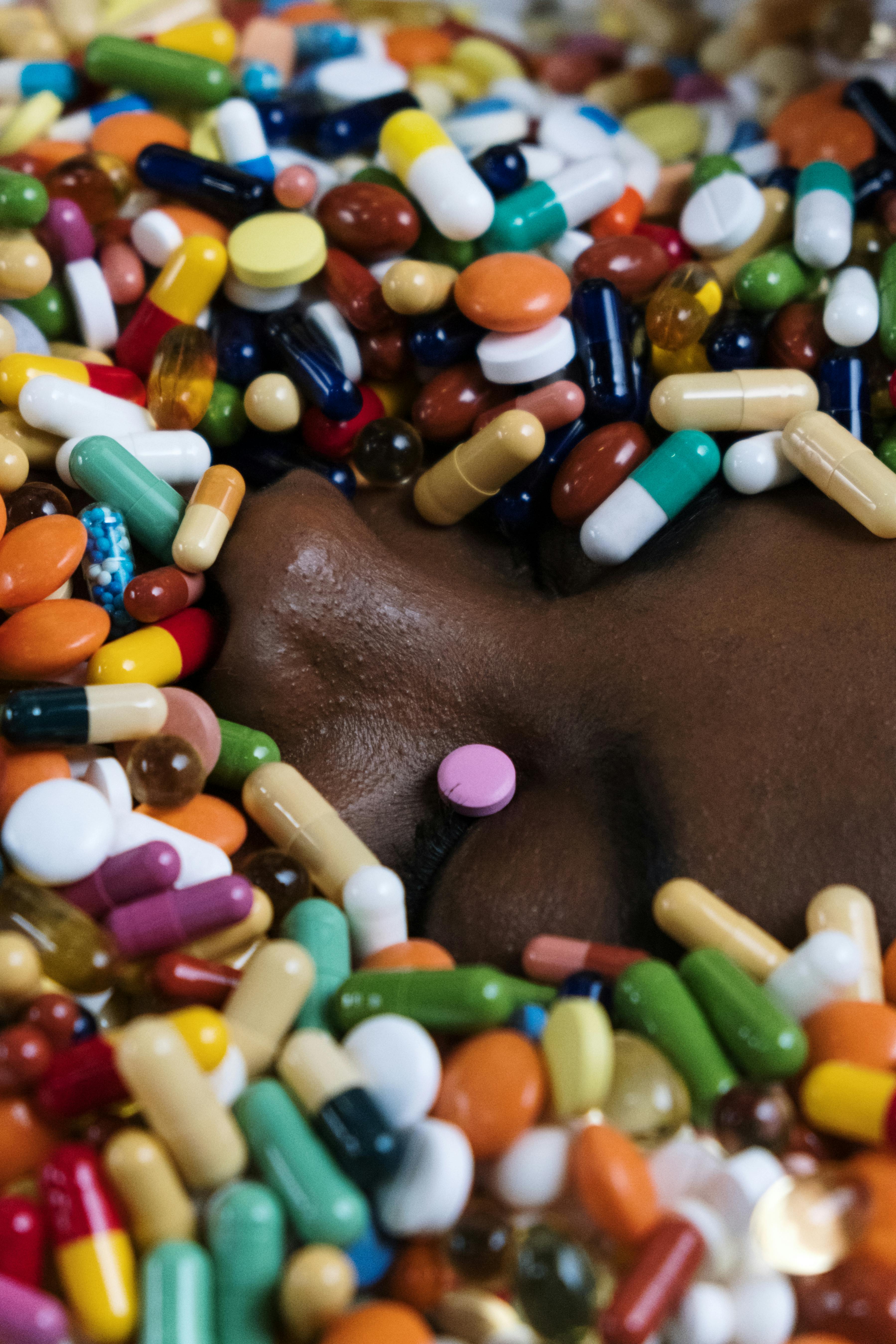 Close-up of a Person Buried in an Assortment of Pills · Free Stock Photo