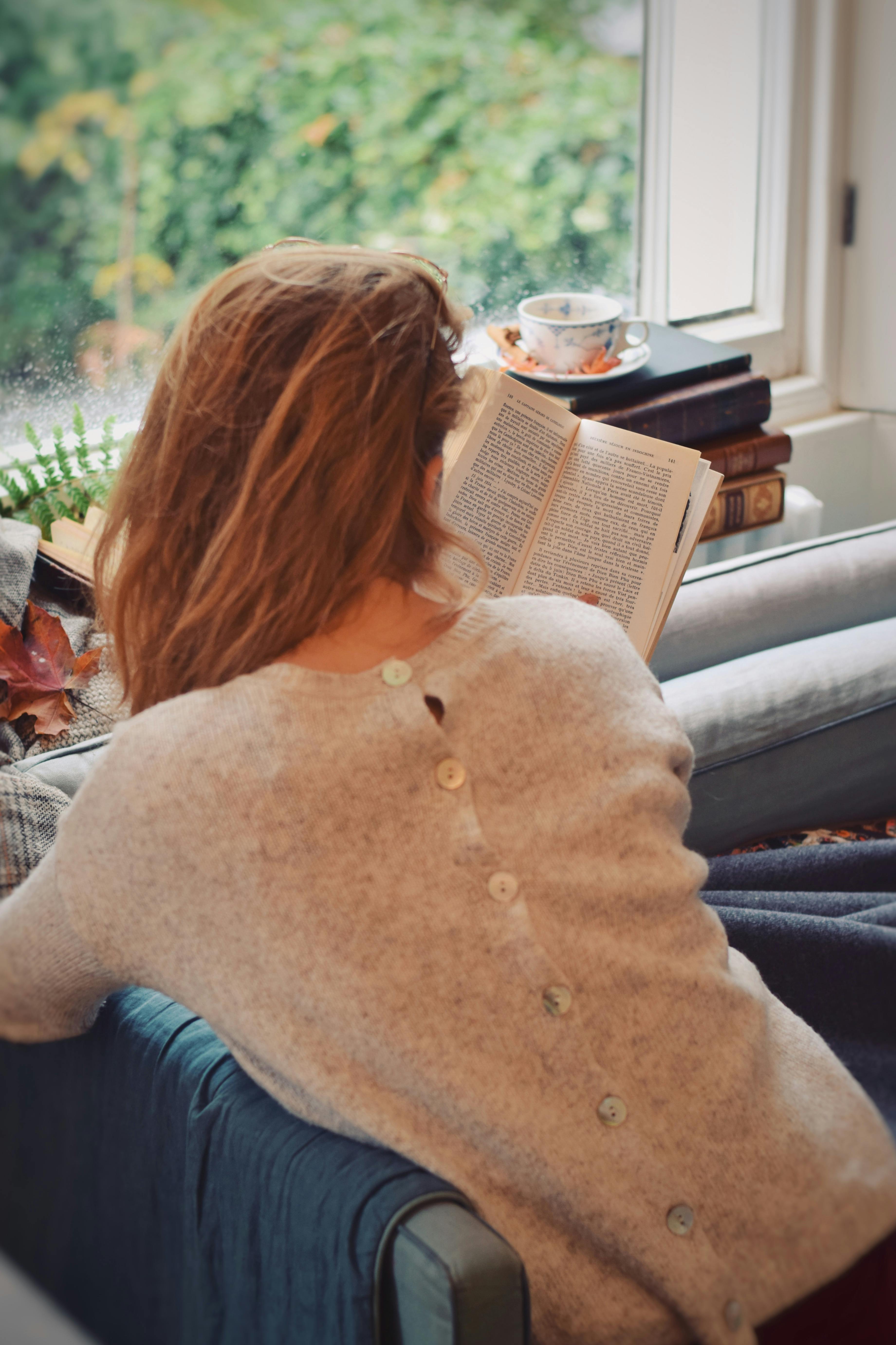Back View of Woman Sitting Reading a Book · Free Stock Photo