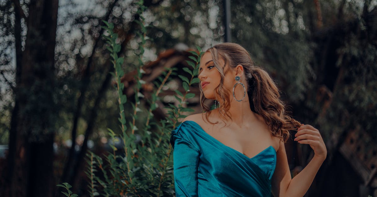 Woman In Blue Off Shoulder Satin Dress Standing Near Green Trees · Free