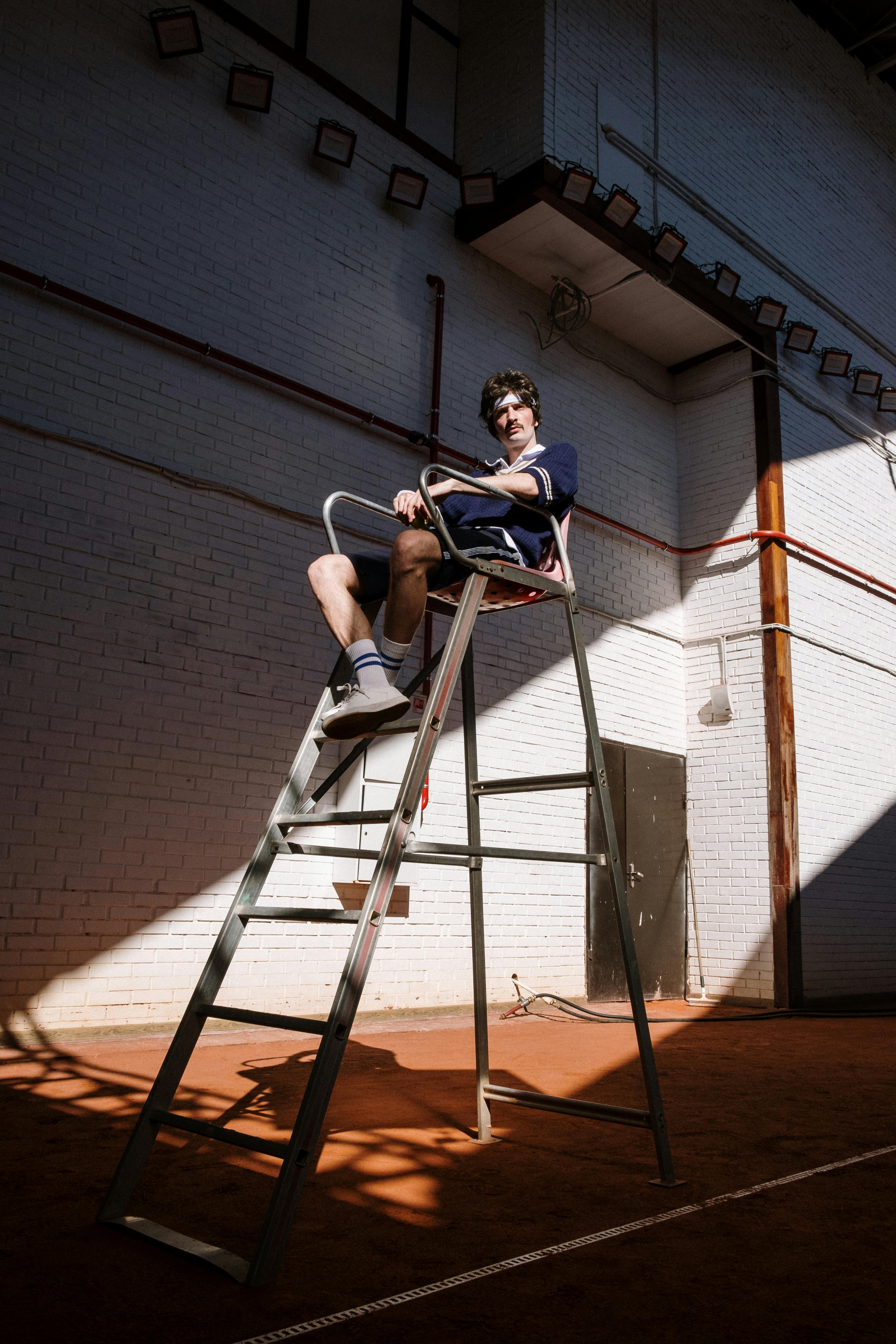 Low-Angle Shot of a Man Sitting on an Umpire Chair · Free Stock Photo