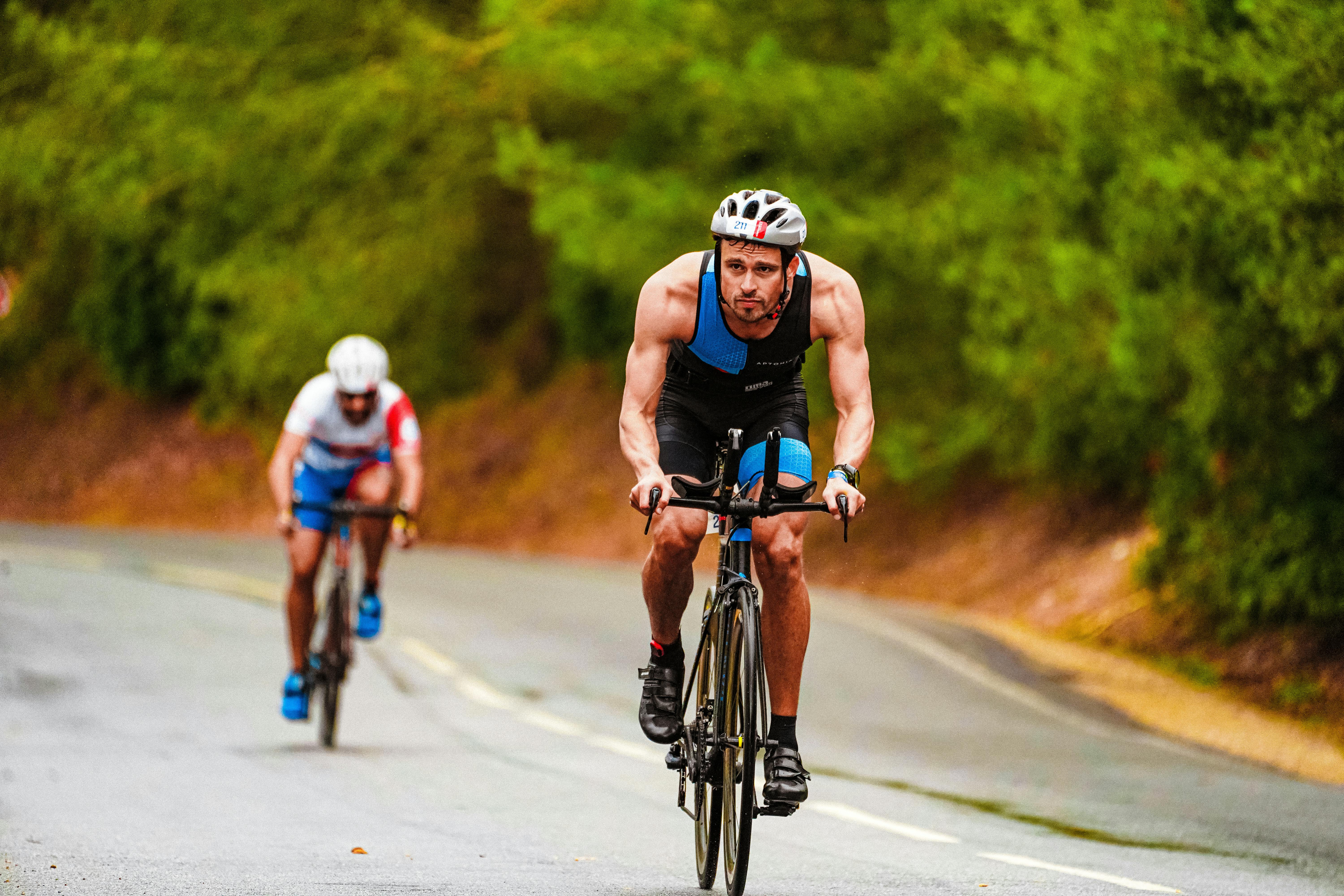 Sporty men riding bikes on uneven asphalt road out of city · Free Stock ...