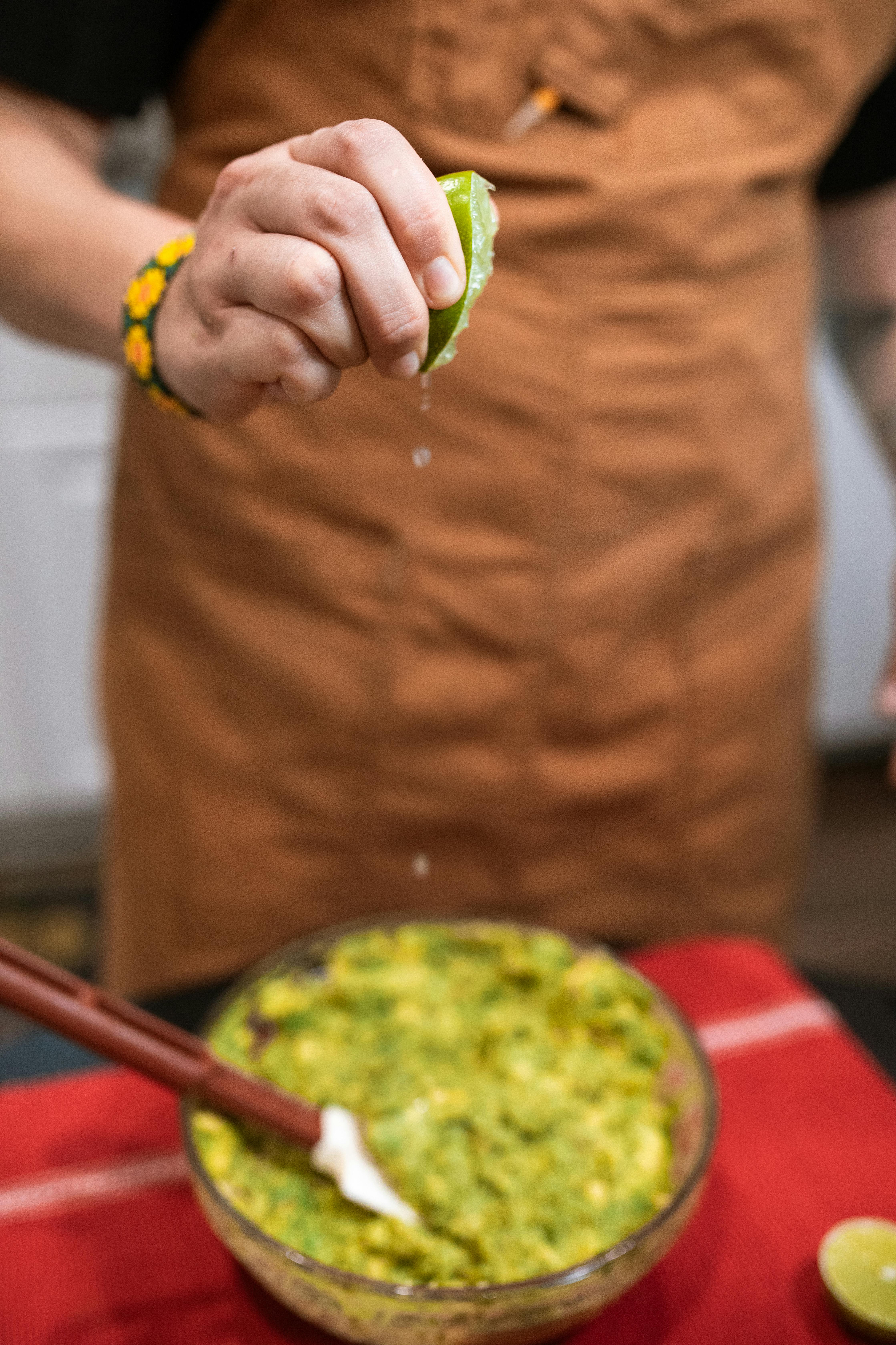A Person's Hand Squeezing a Slice of Lime Over Tacos · Free Stock Photo