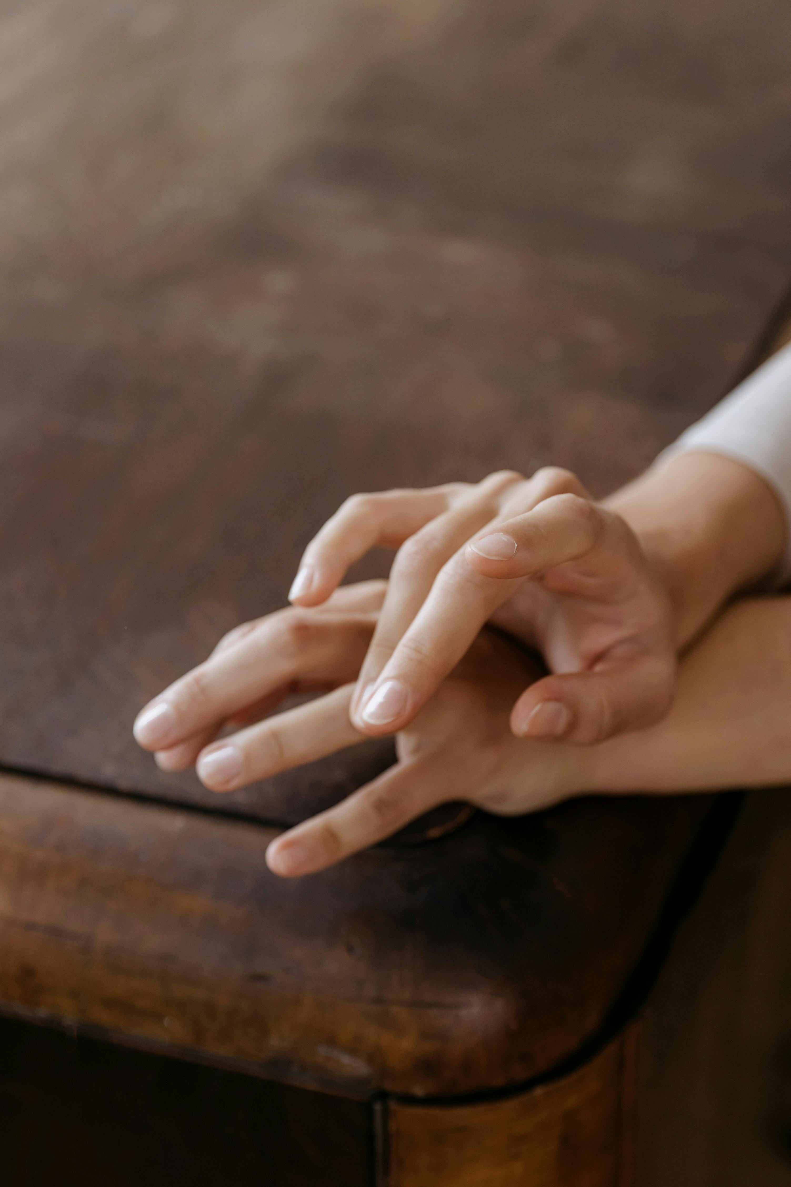 Persons Hands on the Brown Wooden Table · Free Stock Photo