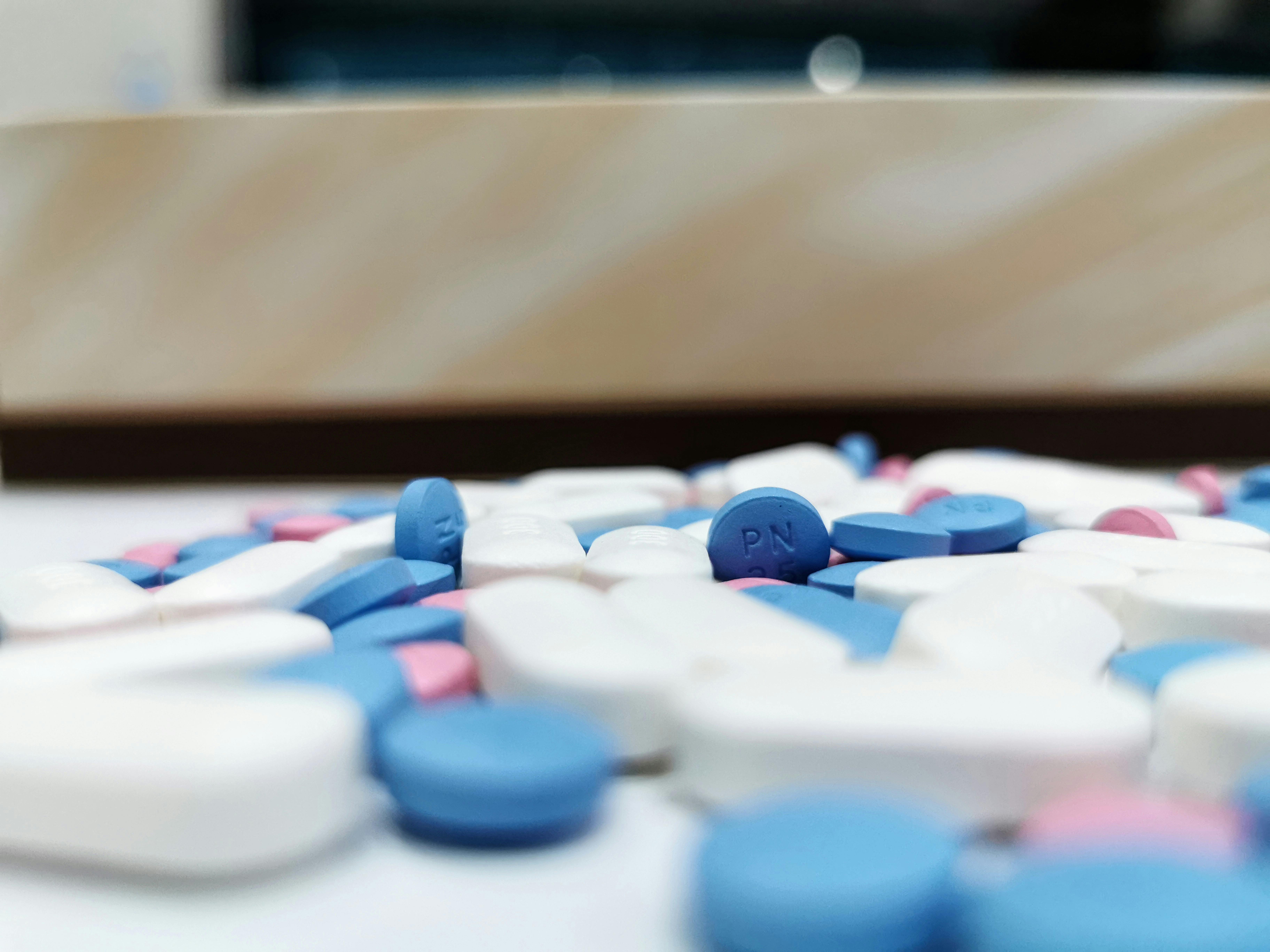 Blue and White Pills on Table · Free Stock Photo