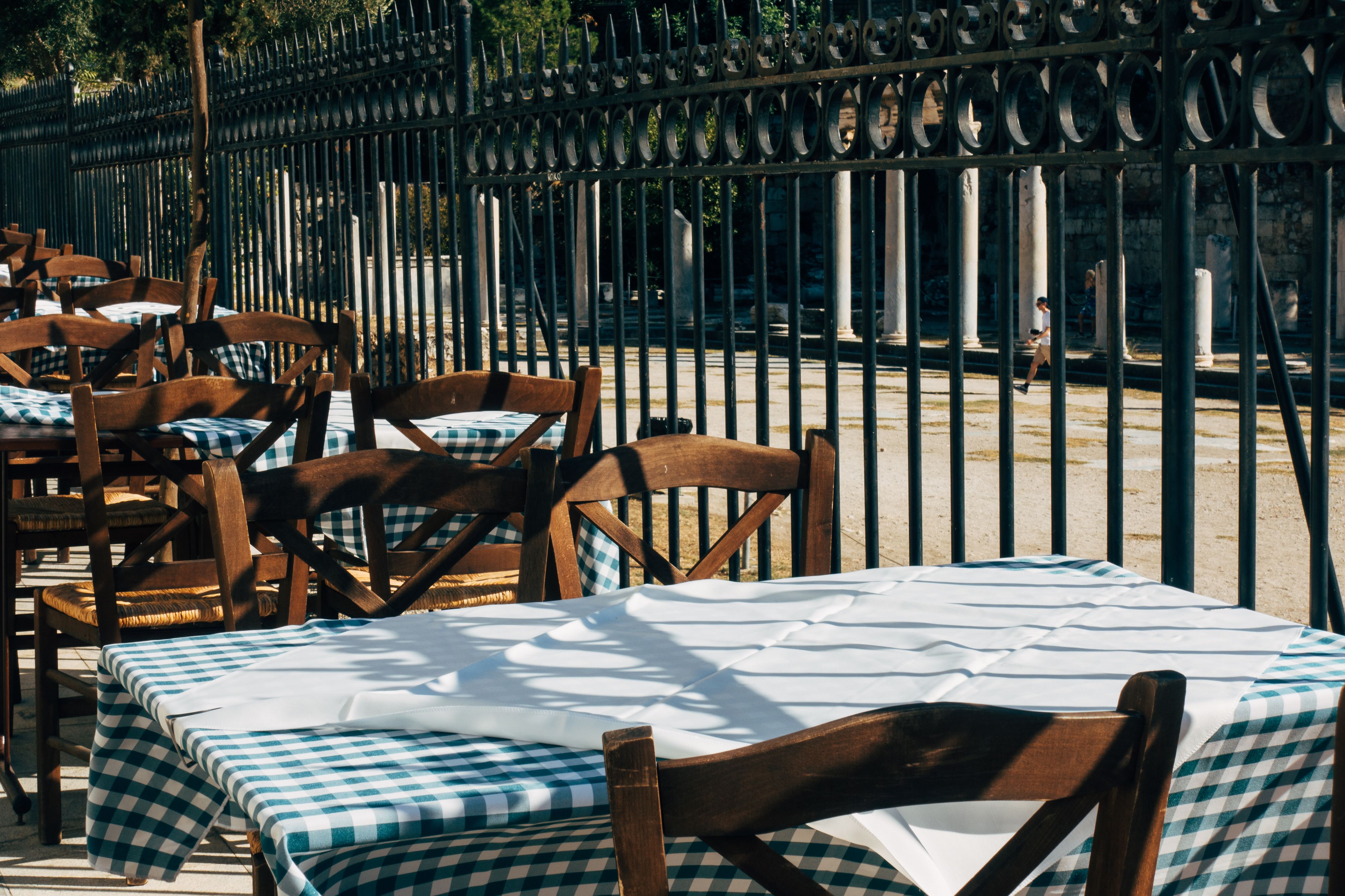 Tables and Chairs of Restaurant Along Fence · Free Stock Photo
