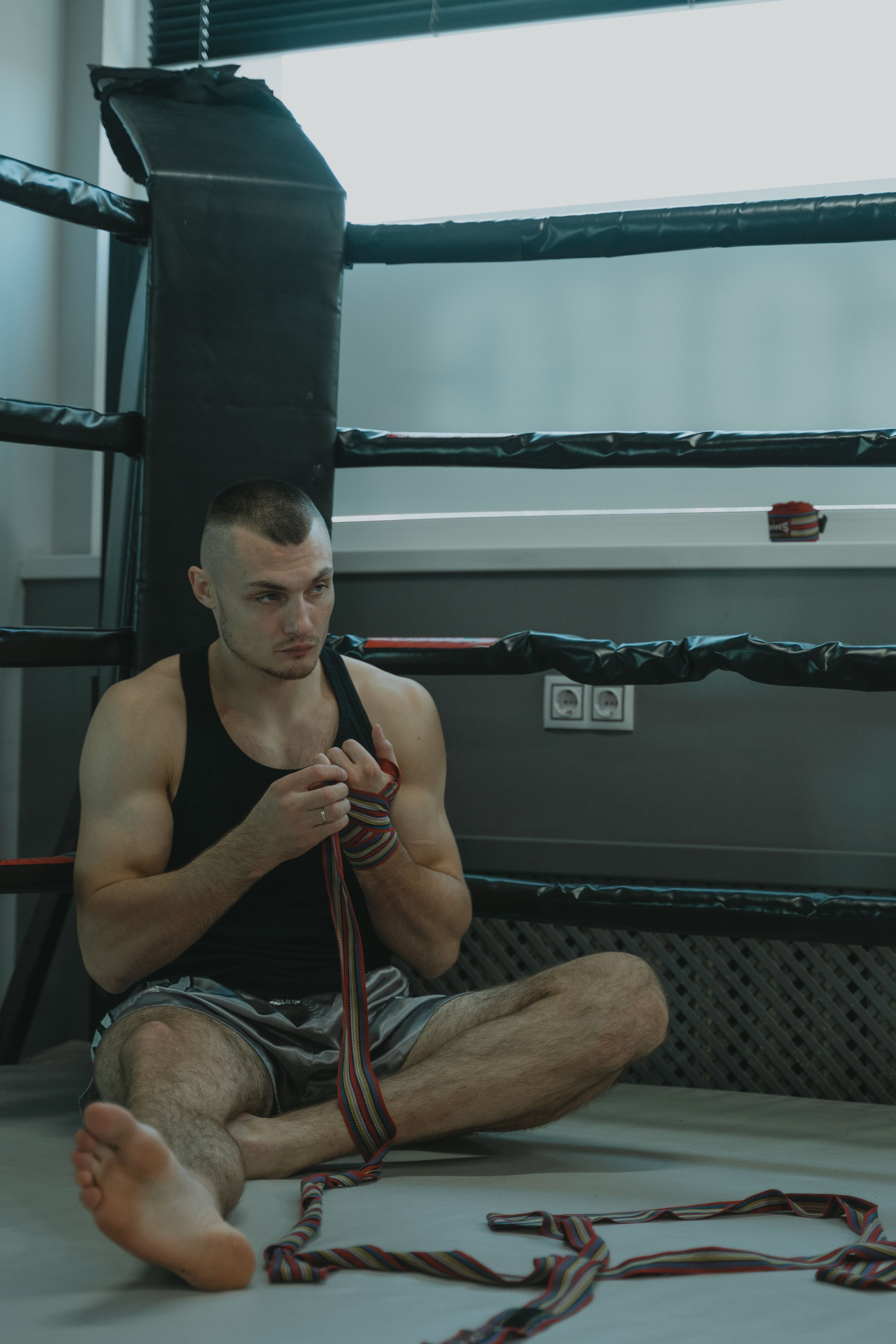 A Man in Black Tank Top Sitting on a Boxing Ring · Free Stock Photo