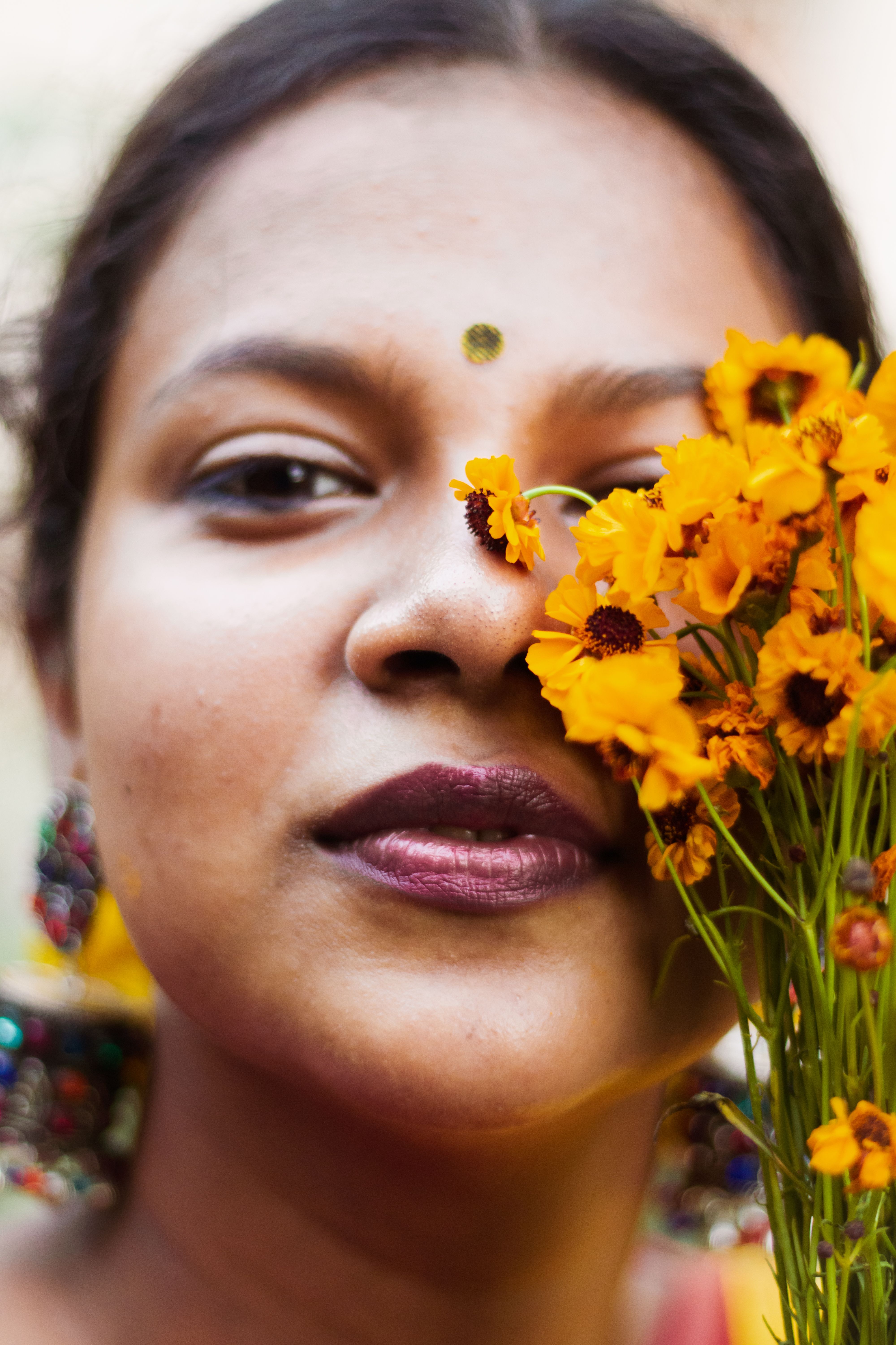Indian woman covering face with flowers · Free Stock Photo