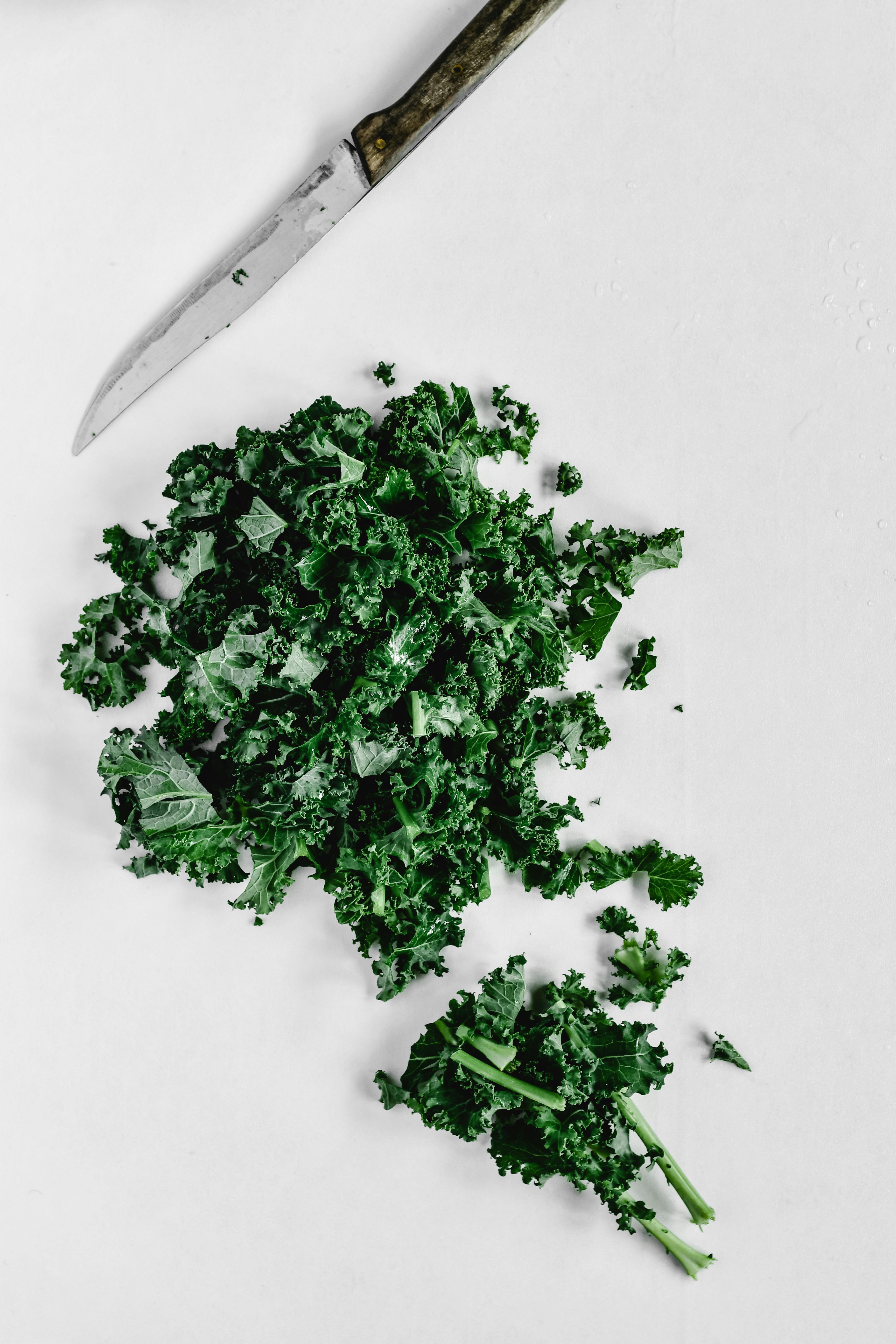 Close-Up Shot of Chopped Kale on a White Surface · Free Stock Photo