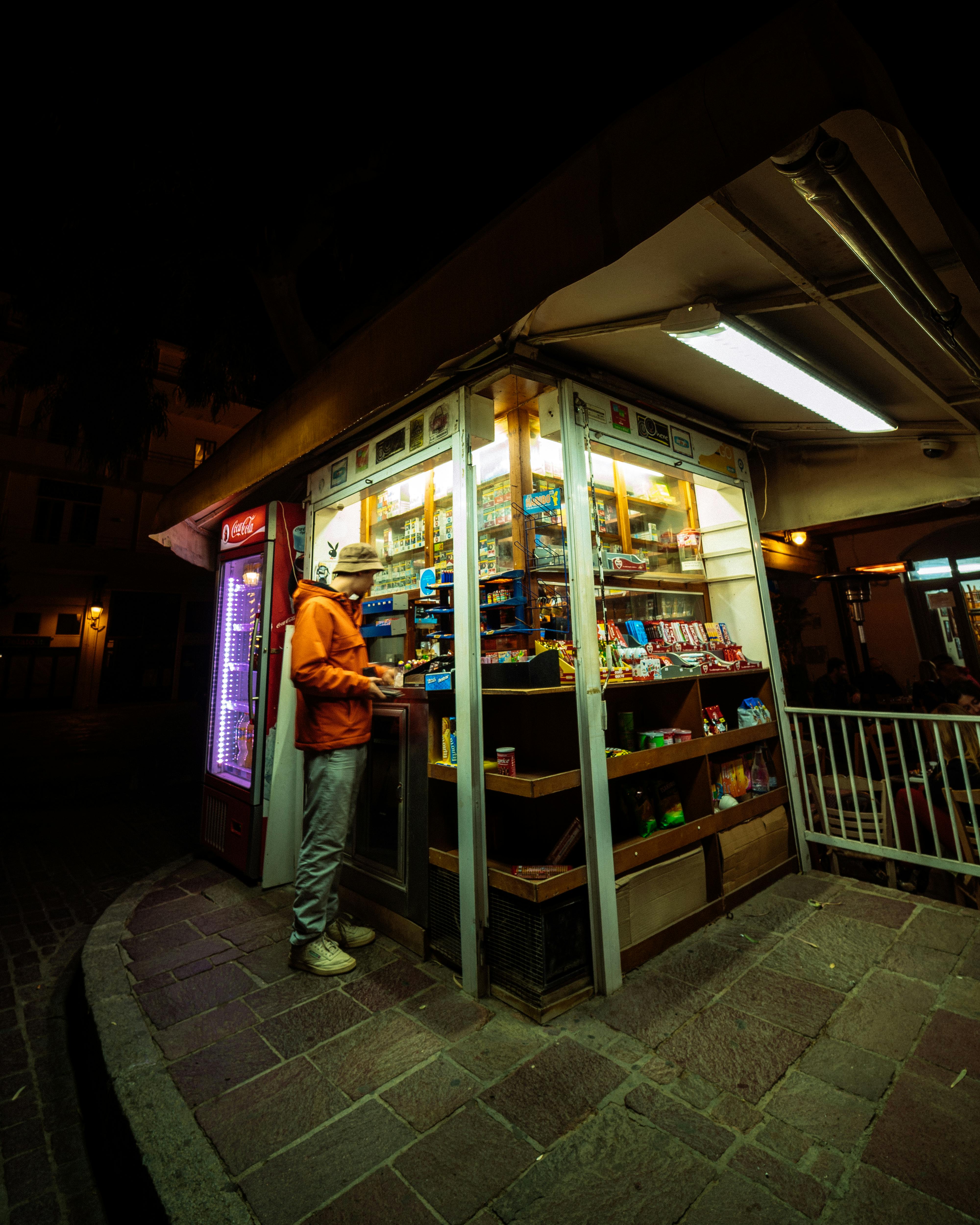 Man in Orange Hoodie Jacket Standing in Front of a Store · Free Stock Photo