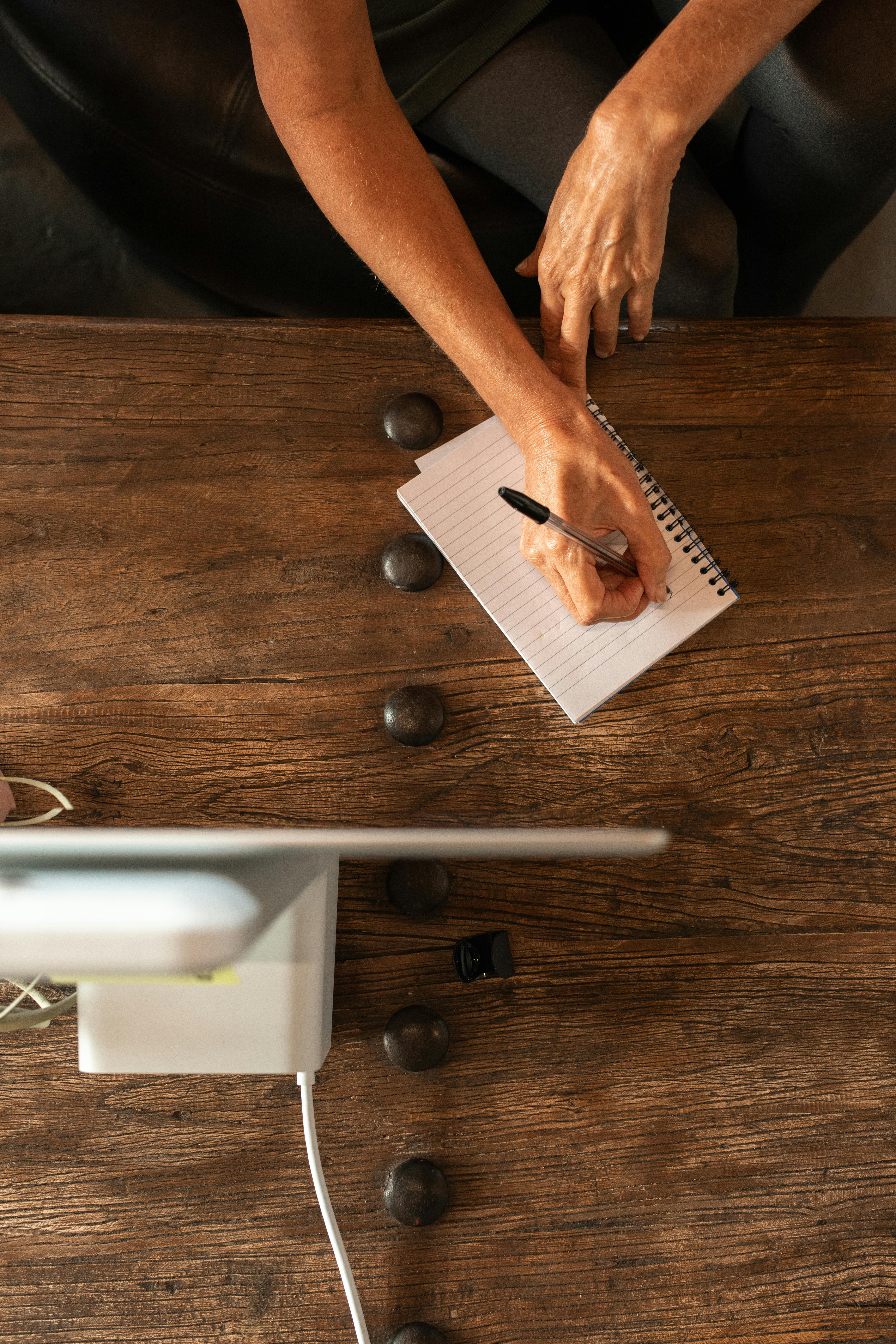 A Person Writing on White Paper · Free Stock Photo