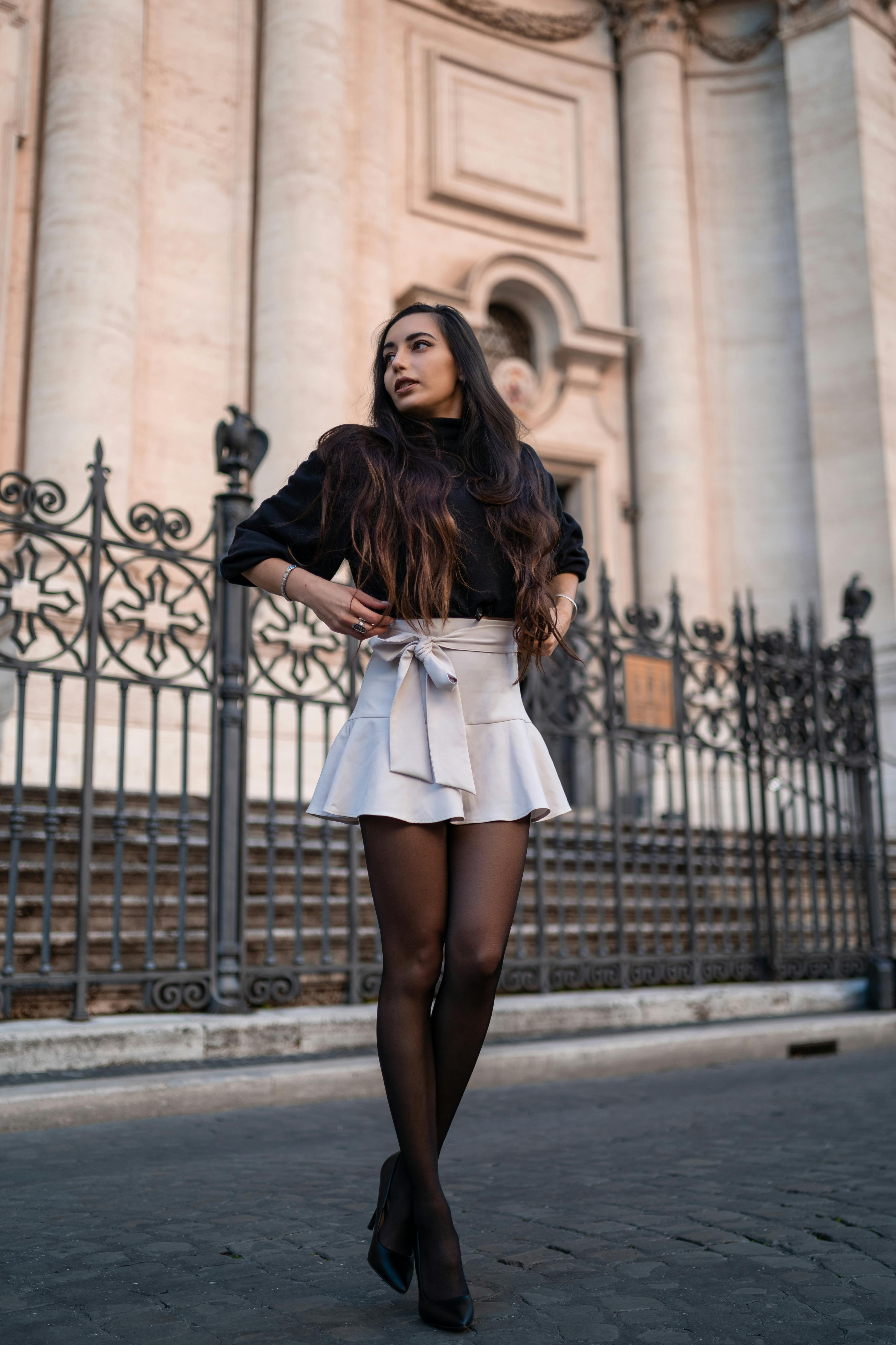 Stylish woman standing outside stone building · Free Stock Photo