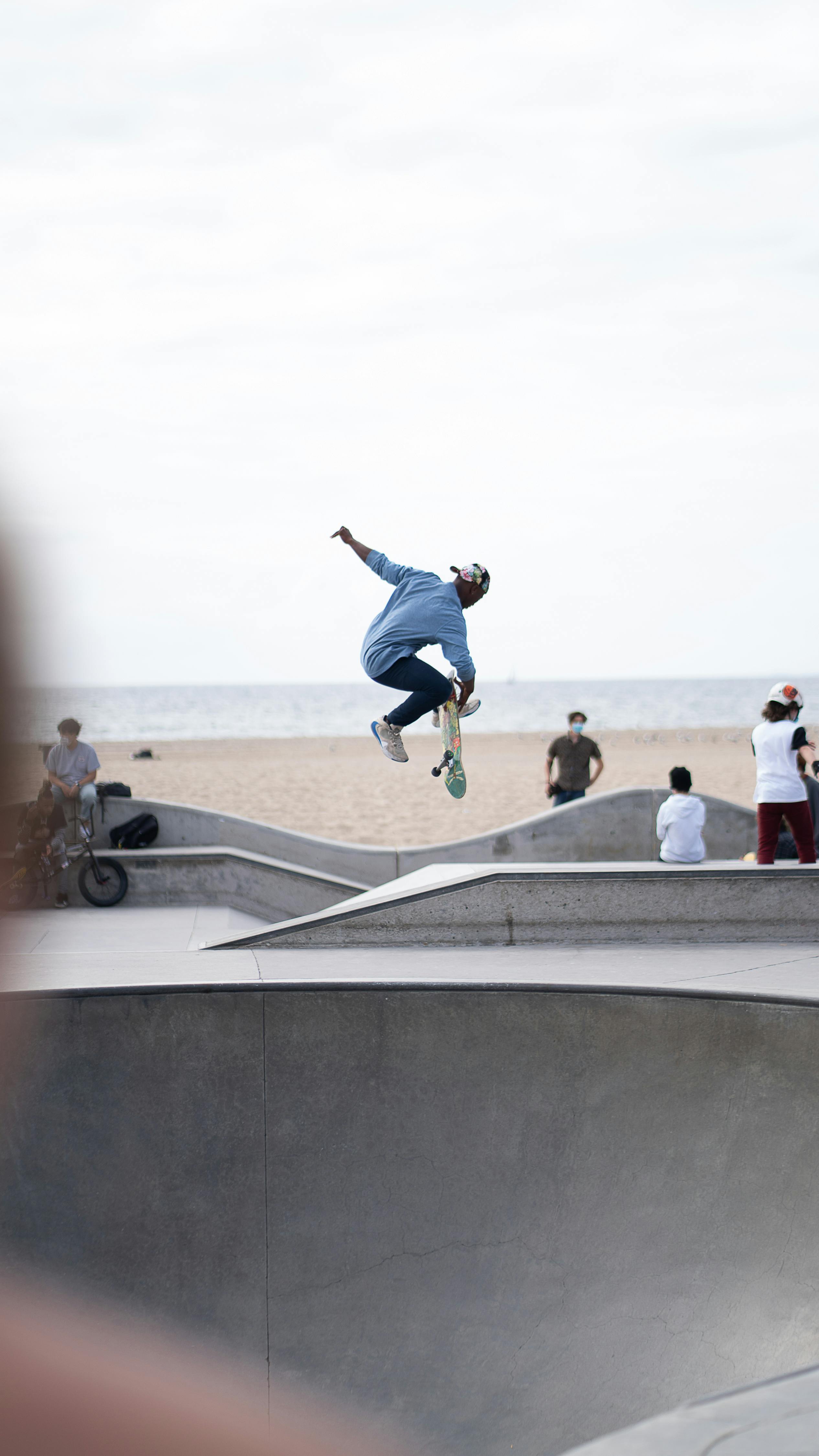 Skater performing trick on skateboard in air above road · Free Stock Photo