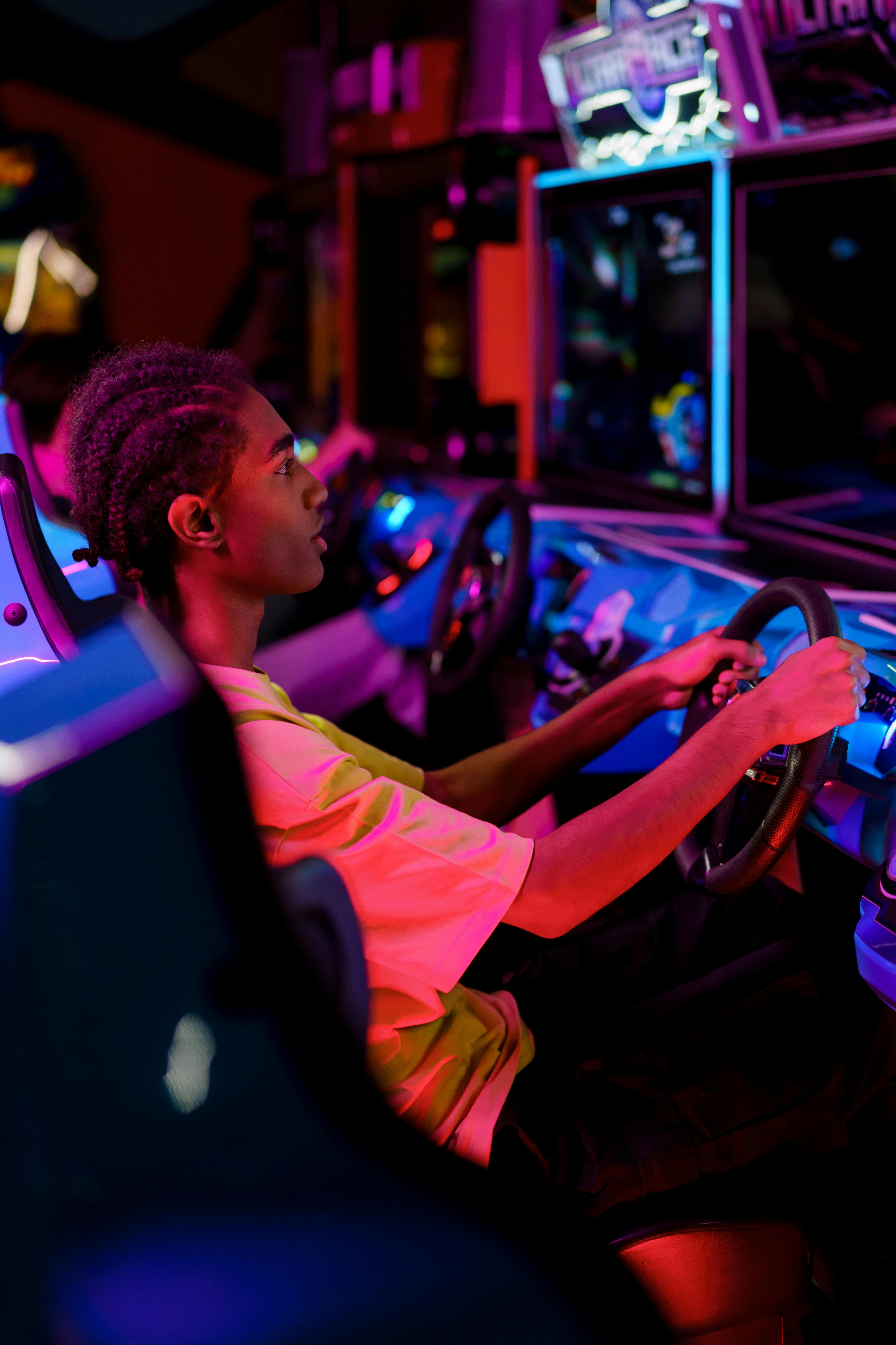 Man Playing in Arcade Machine Inside an Amusement Arcade · Free Stock Photo
