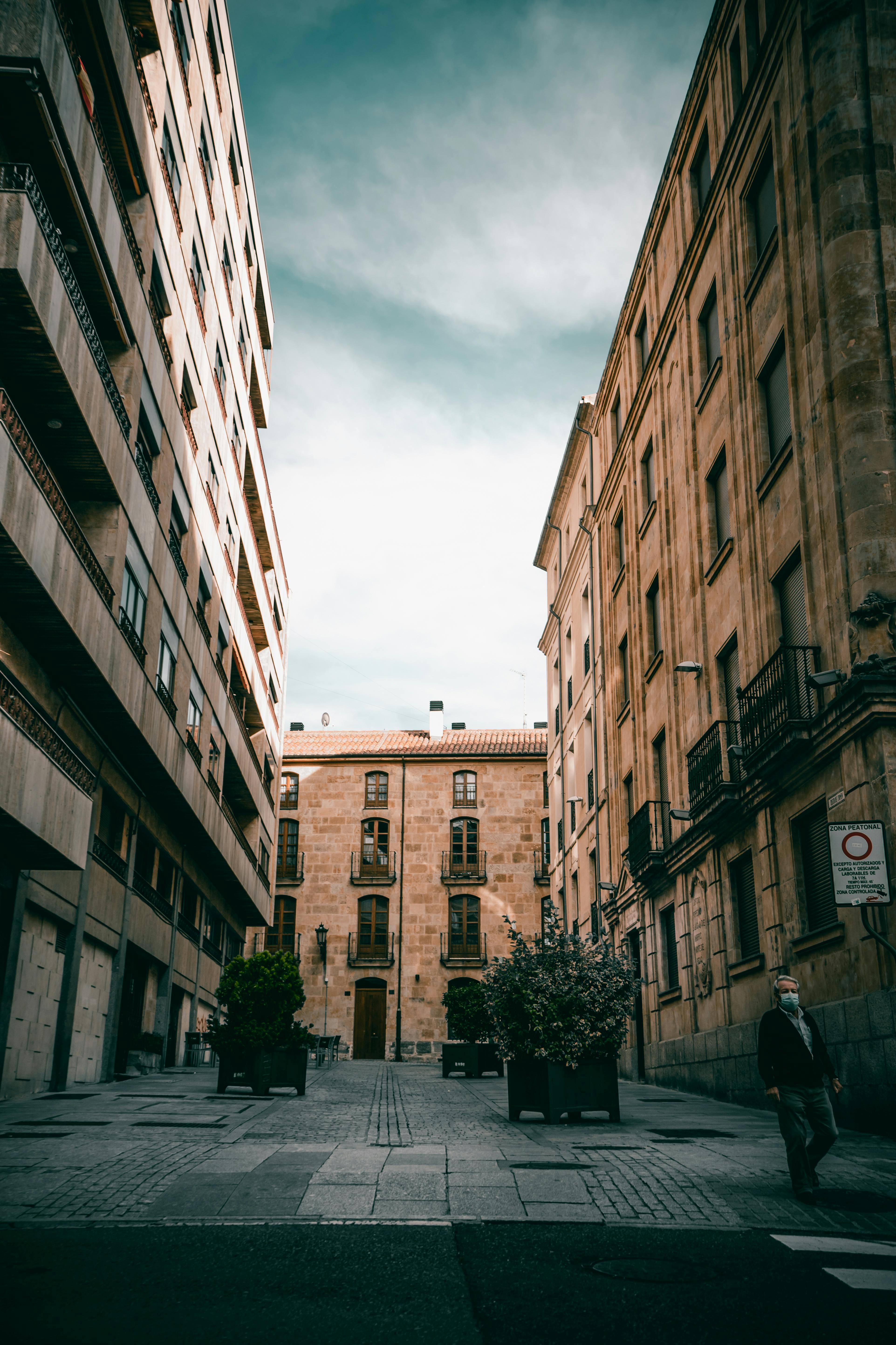 A Man Walking Near Buildings · Free Stock Photo